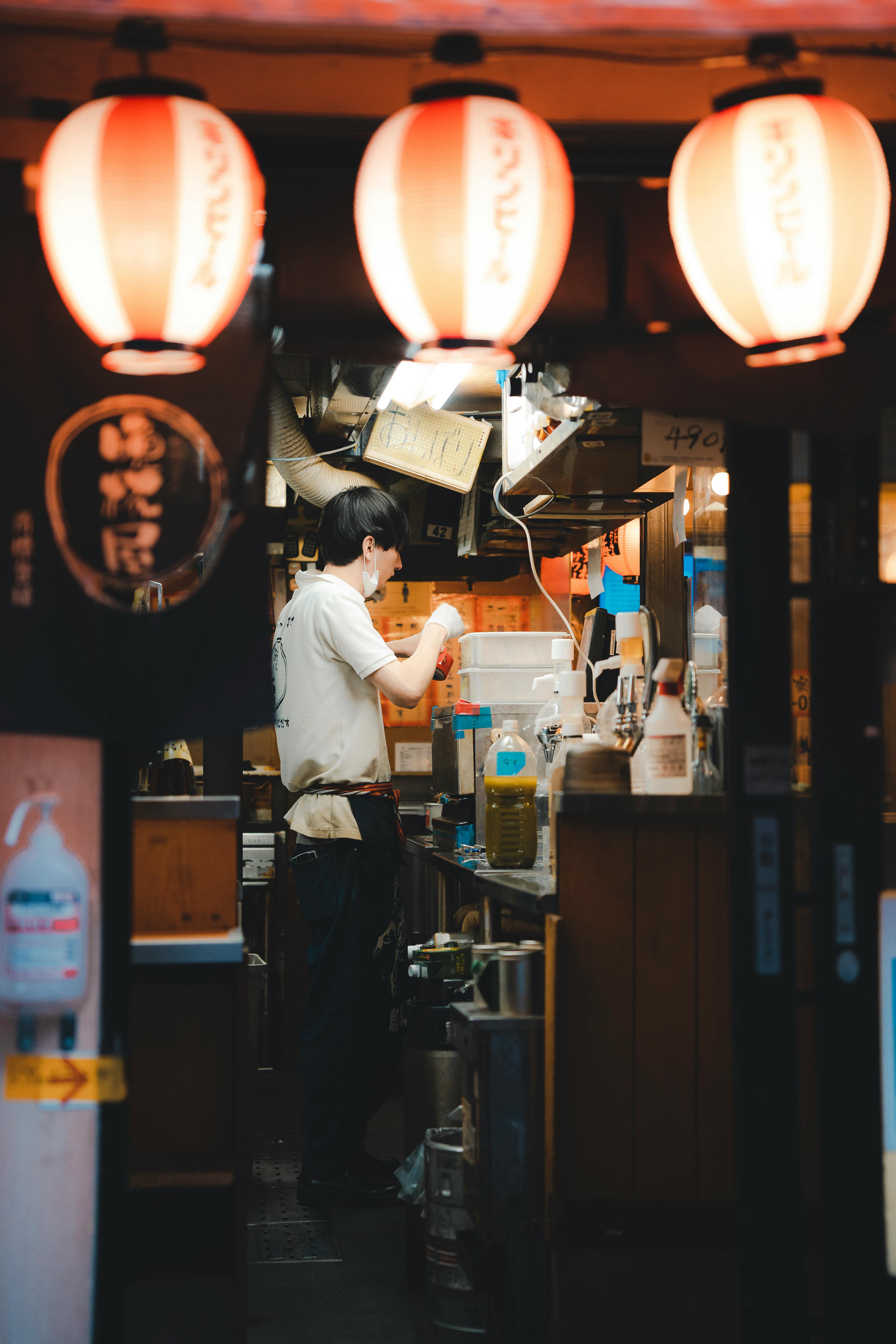 Man Working in Food Bar at Night · Free Stock Photo