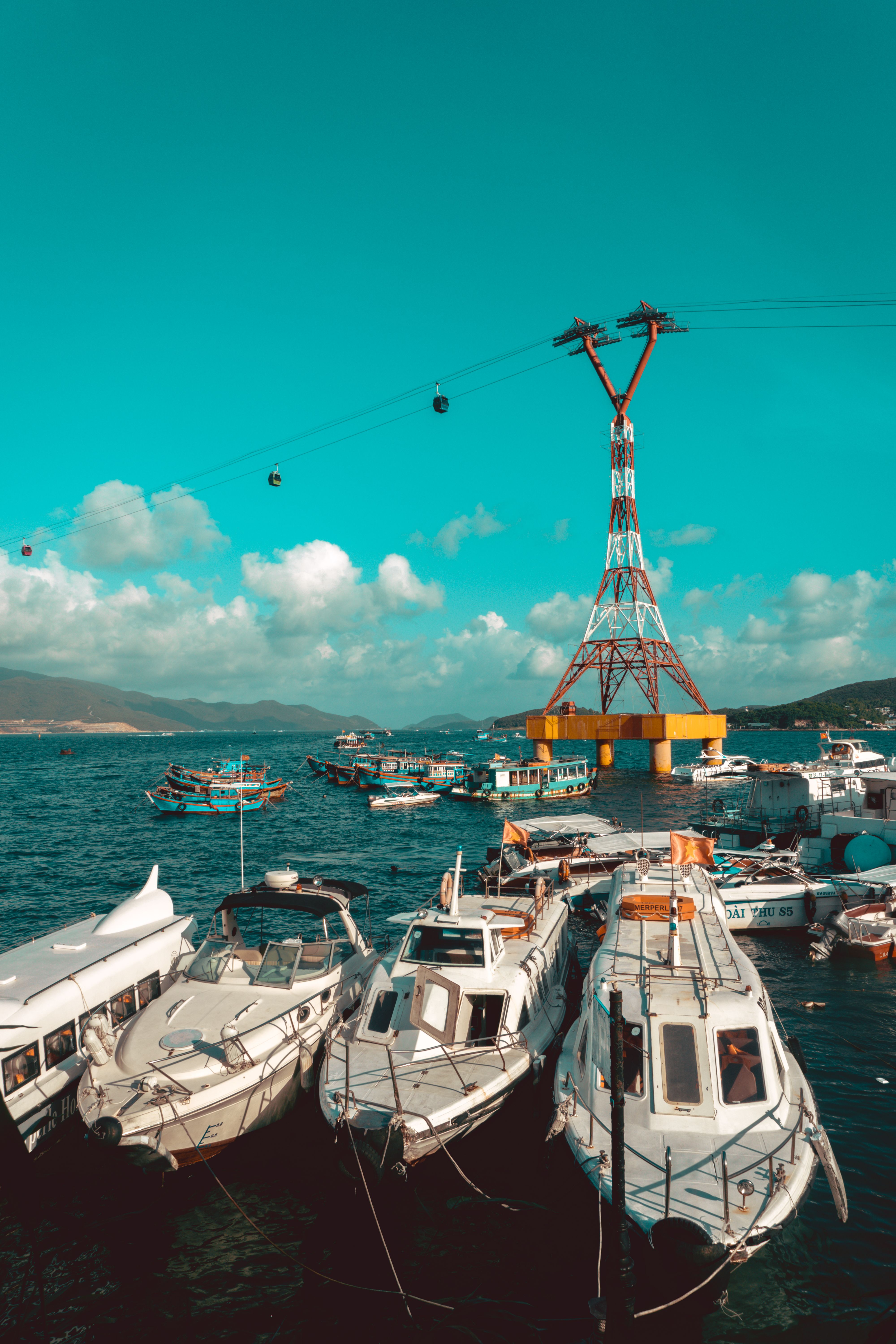 Cable Cart Heading Toward Tower Above Boats · Free Stock Photo