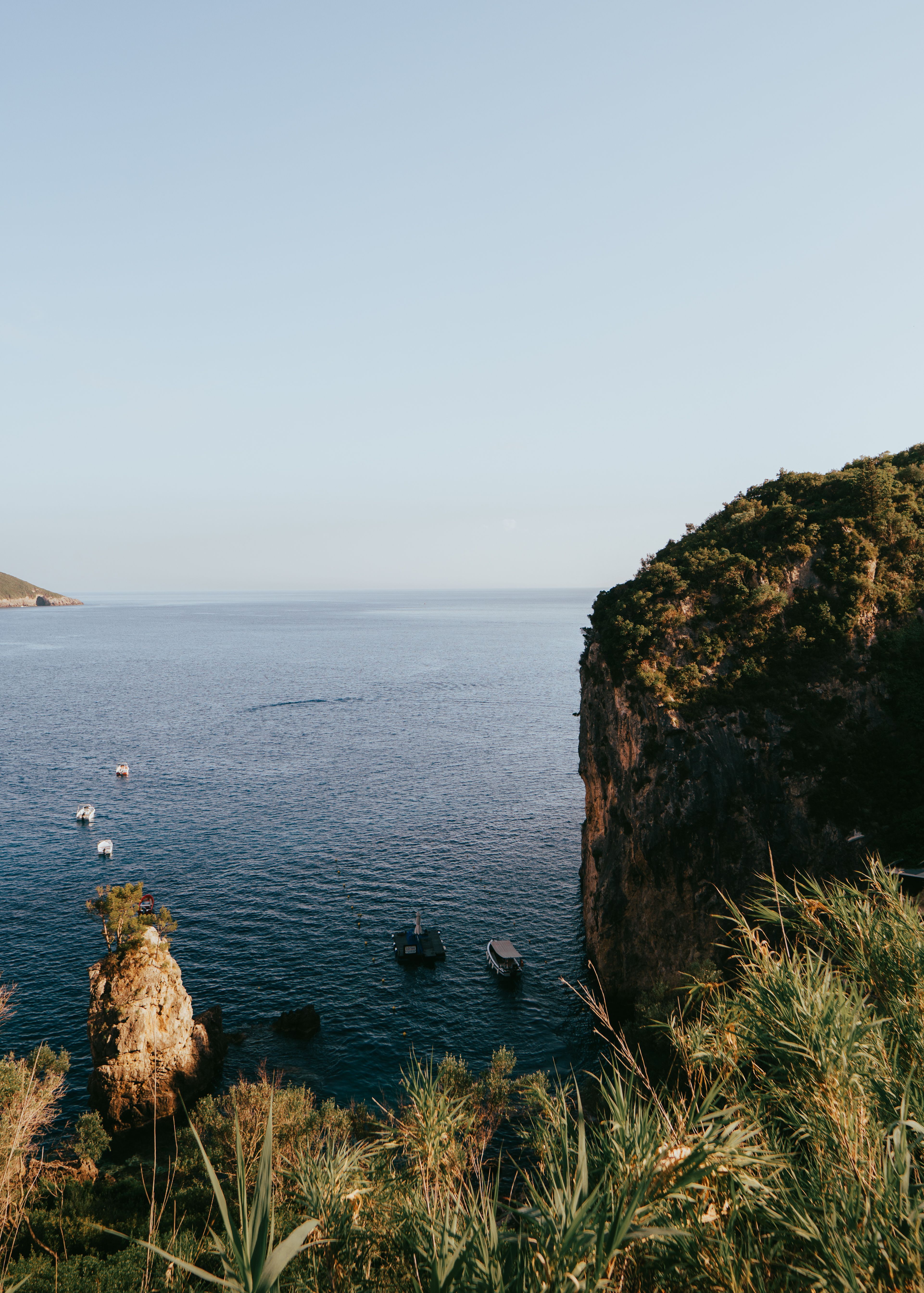 Boats Anchored in the Shadow of a Cliff · Free Stock Photo