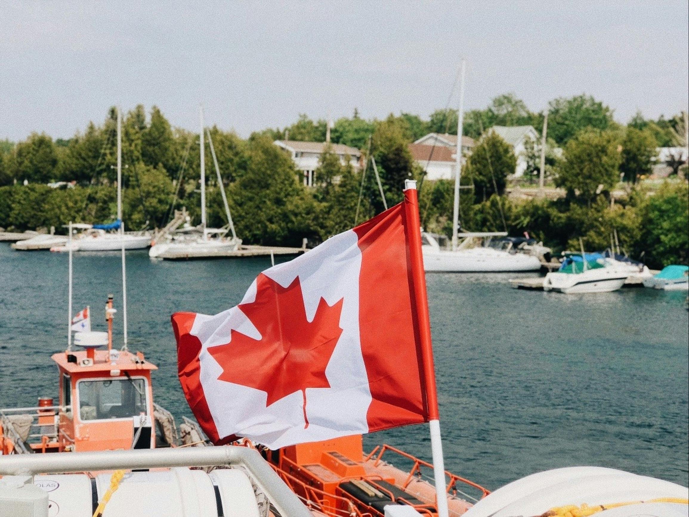 A canadian flag flying on a boat · Free Stock Photo