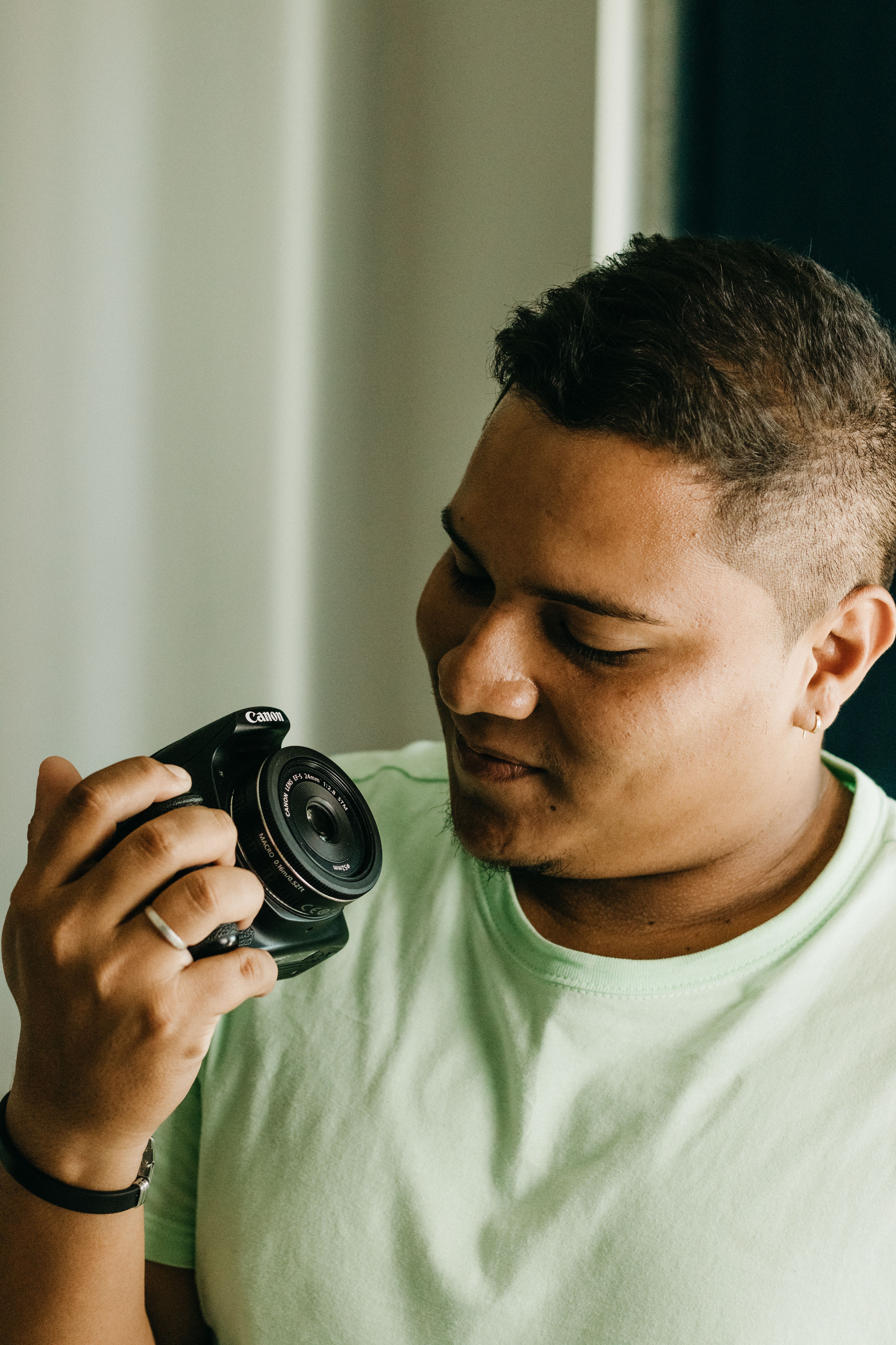 Man Looking into the Lens of a Canon Camera He is Holding · Free Stock ...