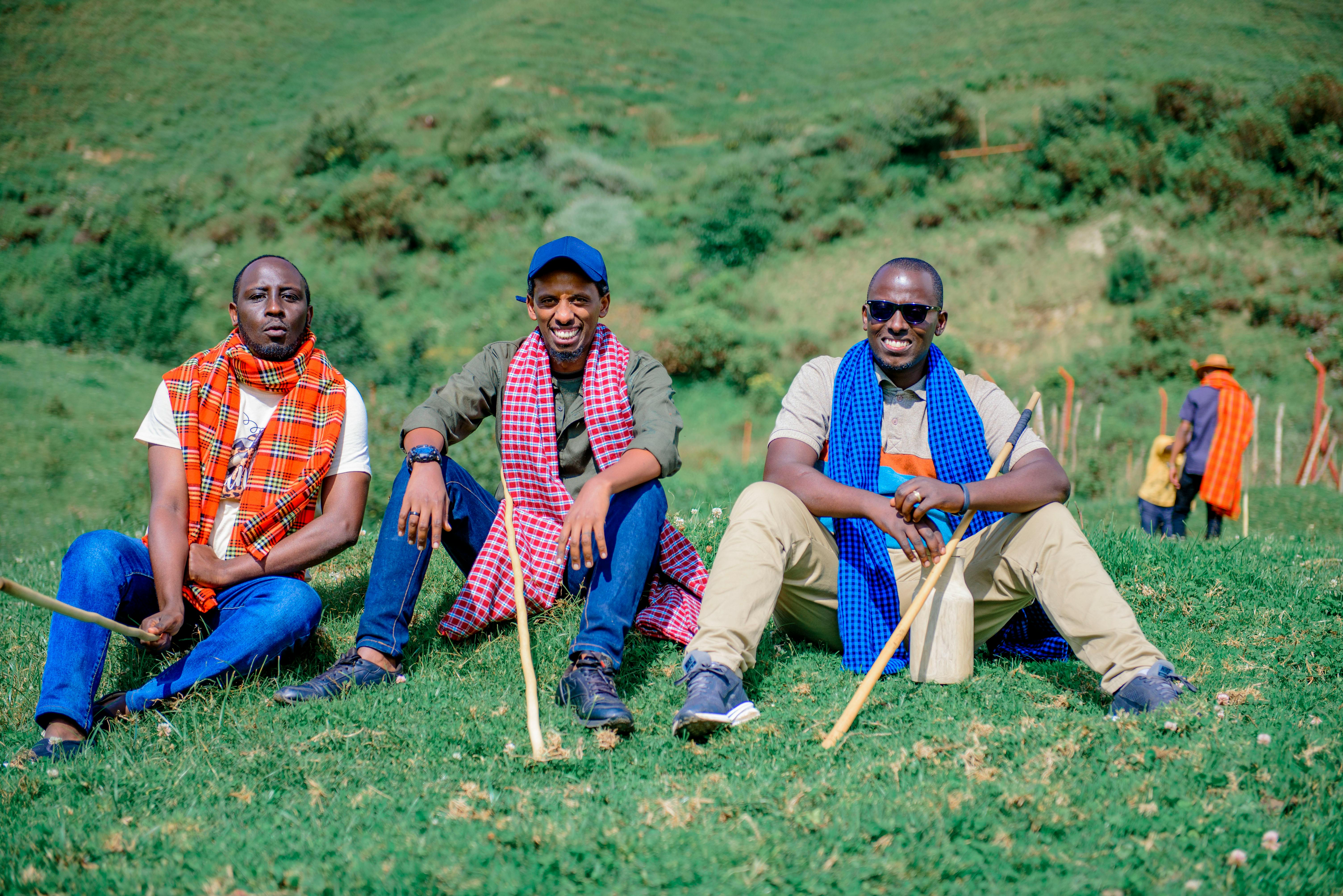 Smiling Men Sitting on Hill in Mountains · Free Stock Photo
