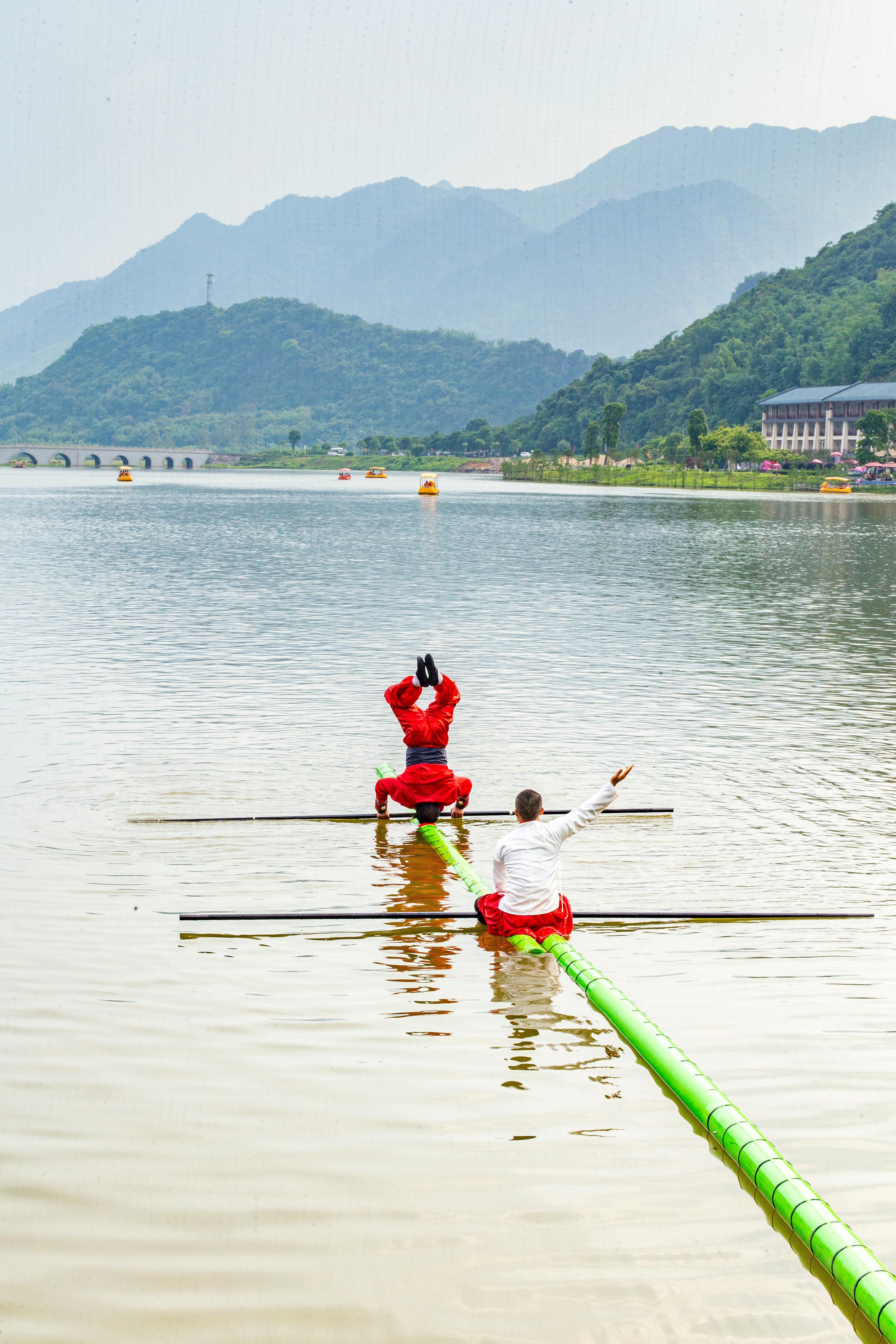 People Balancing on Pipe on River · Free Stock Photo