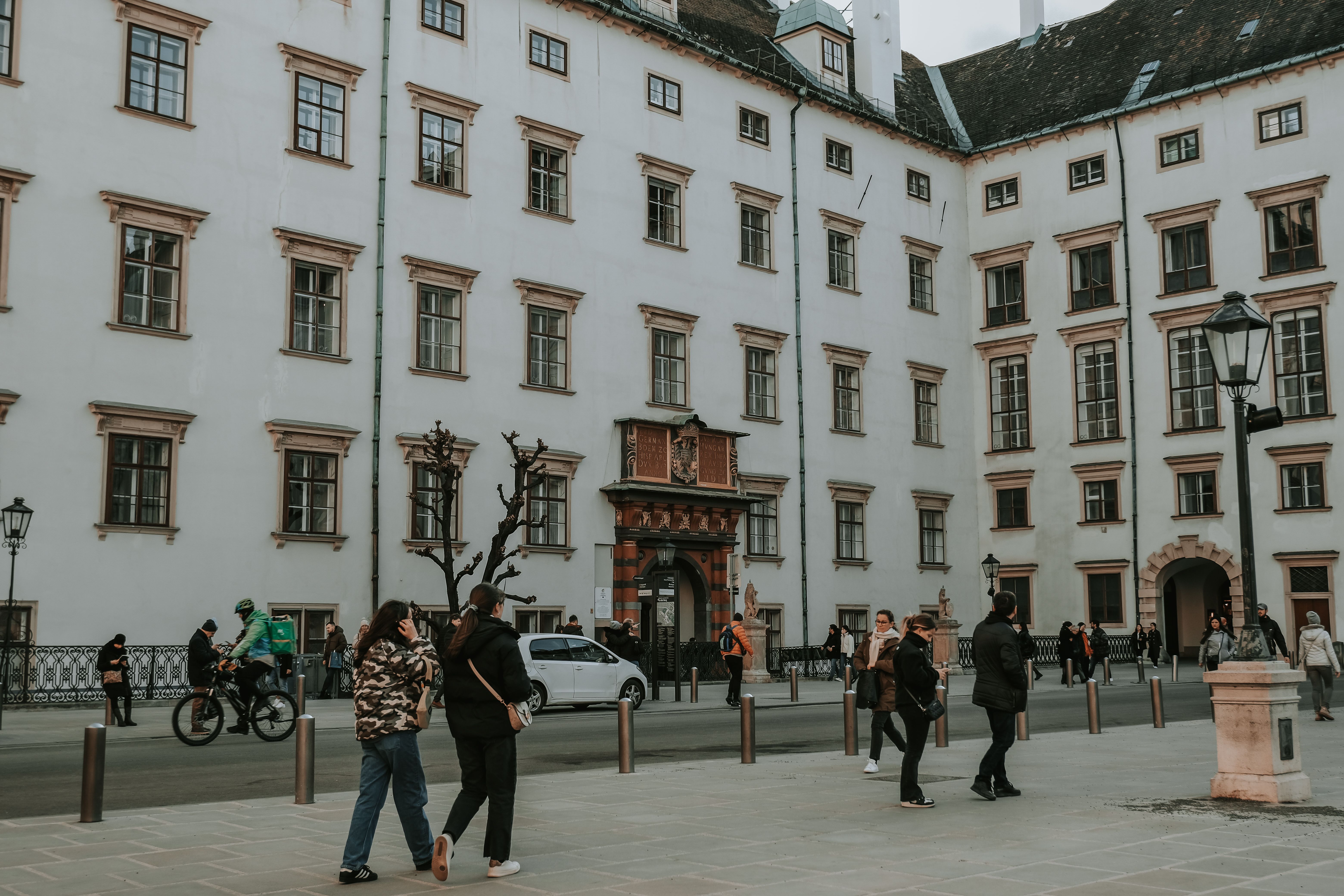 People walking in front of a large building · Free Stock Photo