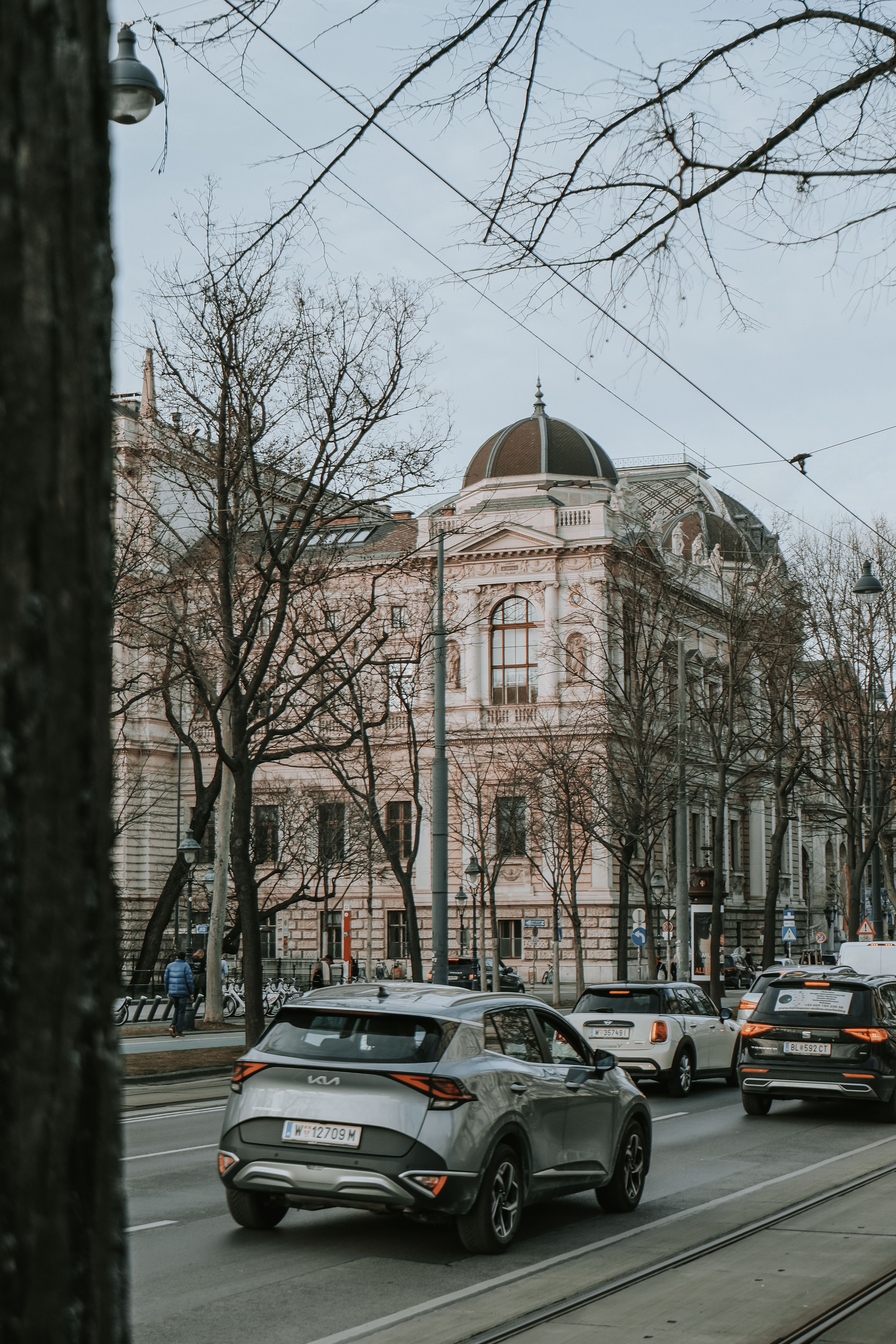 Cars driving down a street in front of a building · Free Stock Photo