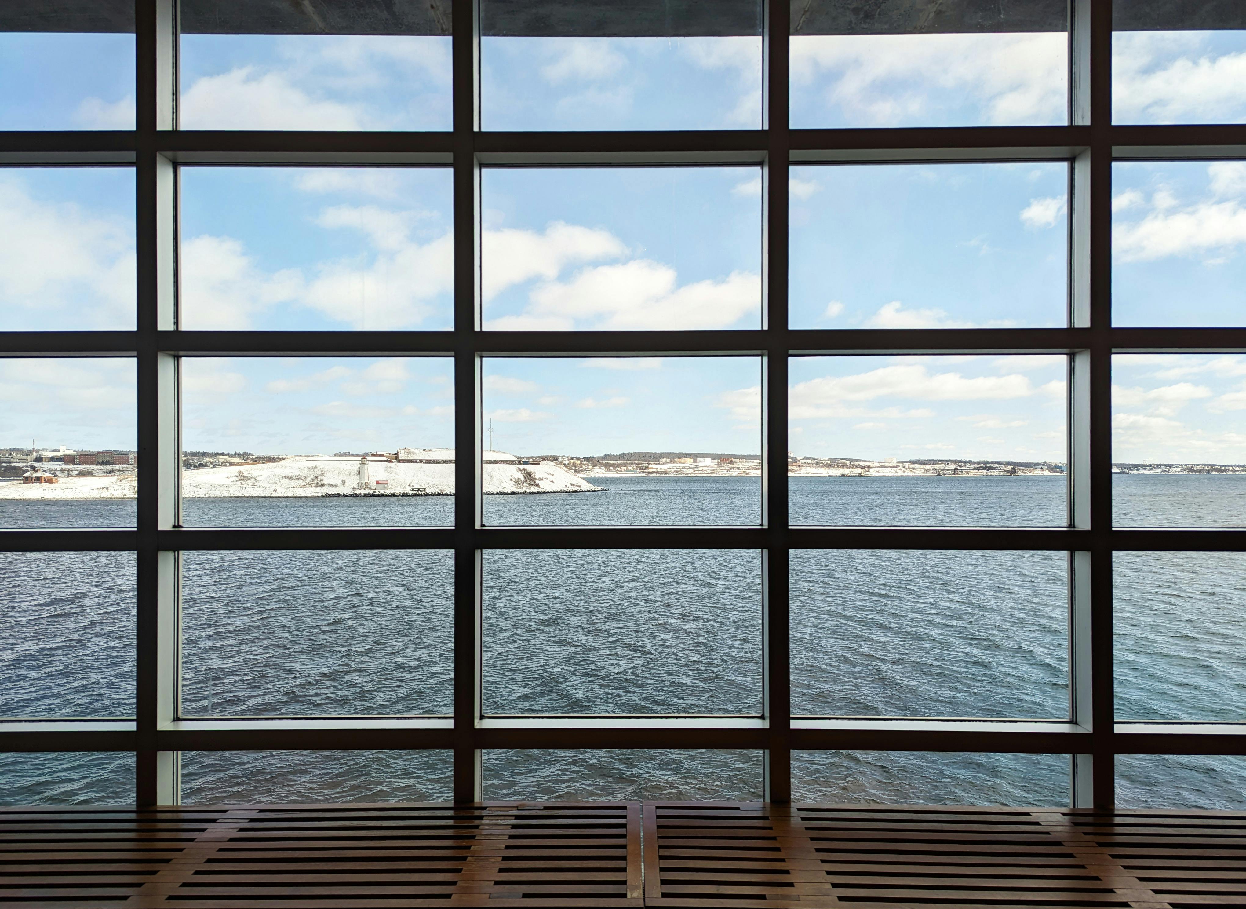 Sea Shore behind Building Windows · Free Stock Photo