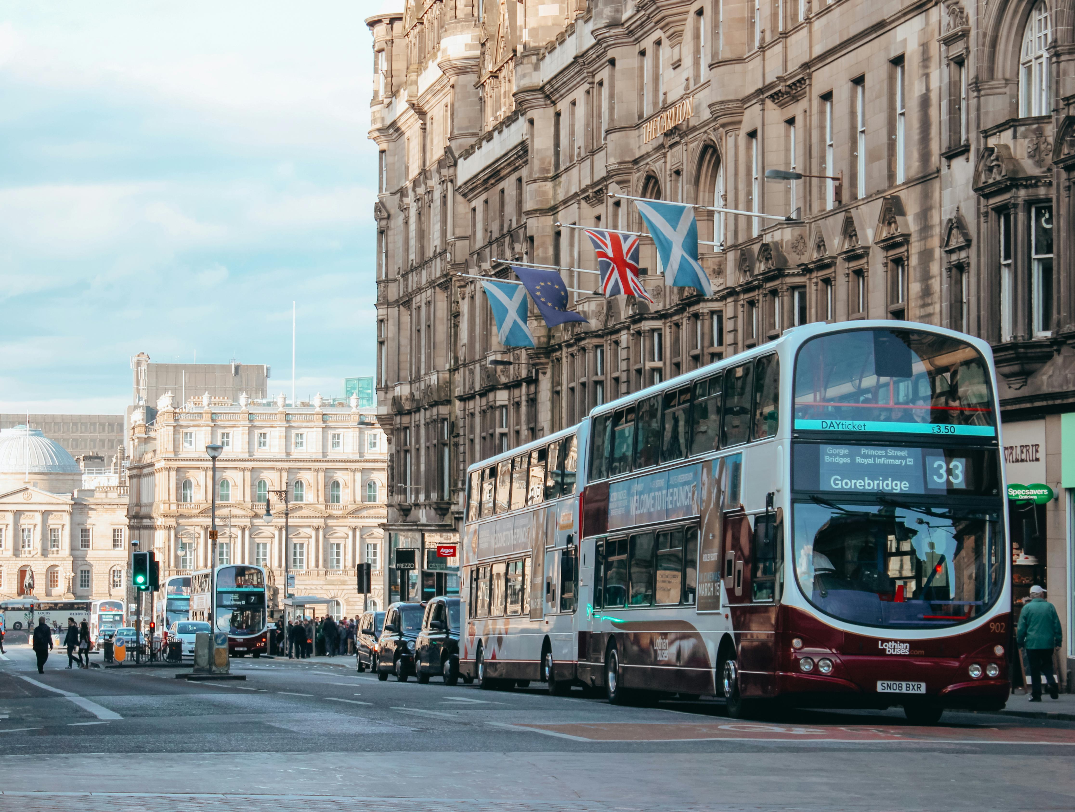 Red Double-decker Bus Passing by a Street in the City · Free Stock Photo