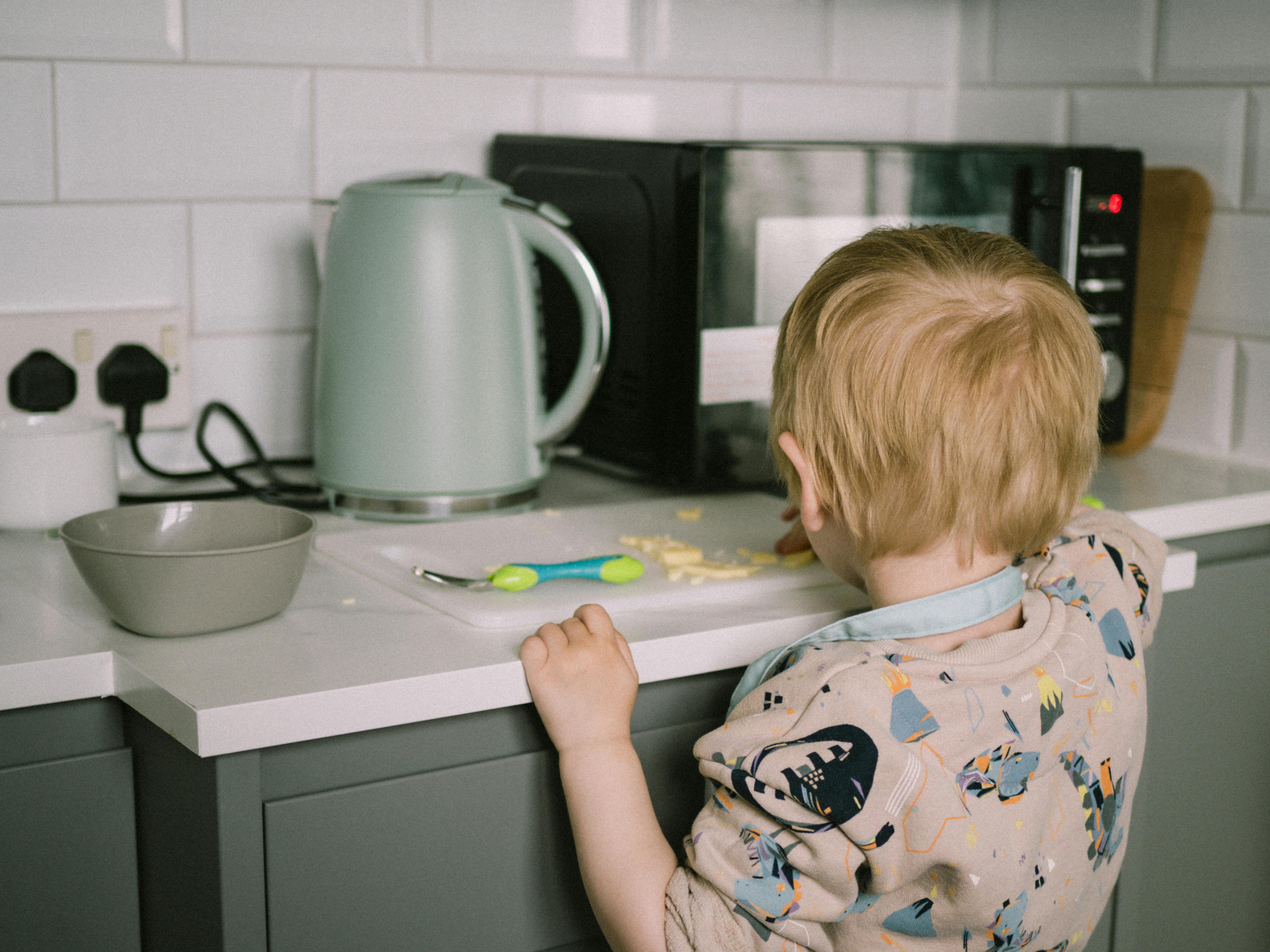 Child Eating Food at Kitchen Counter · Free Stock Photo
