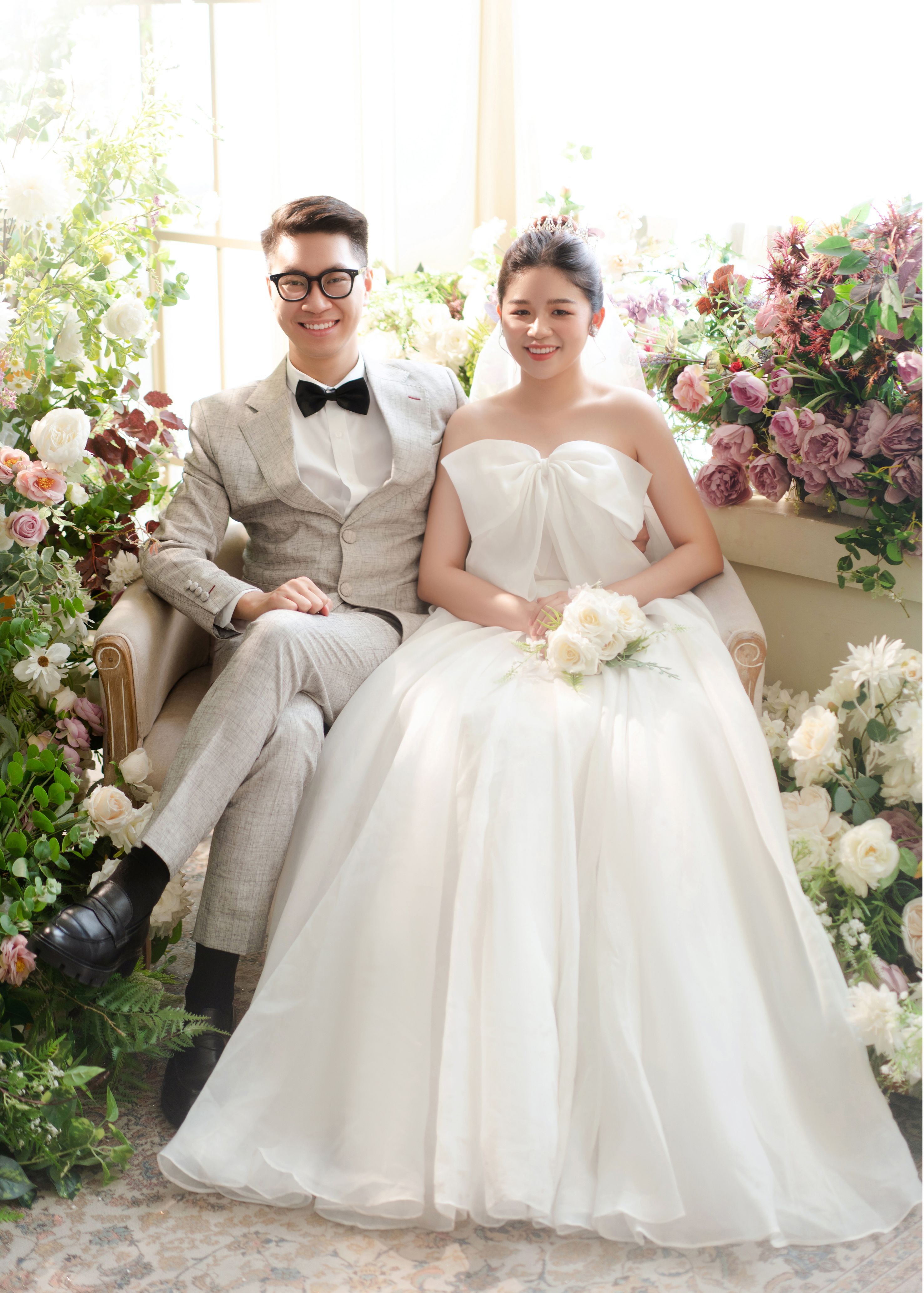 Bride and Groom Sitting on a Couch among Flower Decorations · Free ...