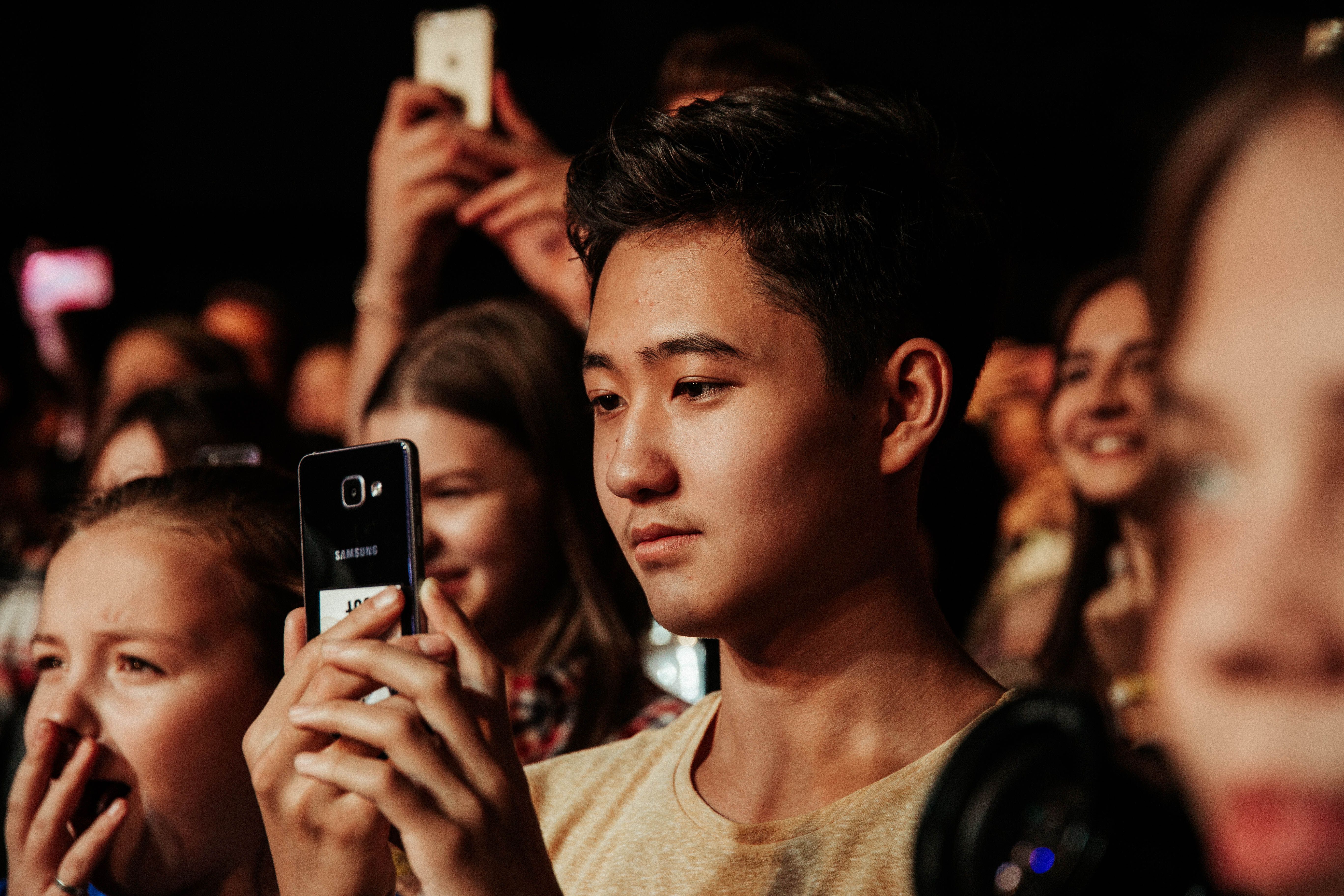 A Group of Young People in the Audience Recording the Performance with ...