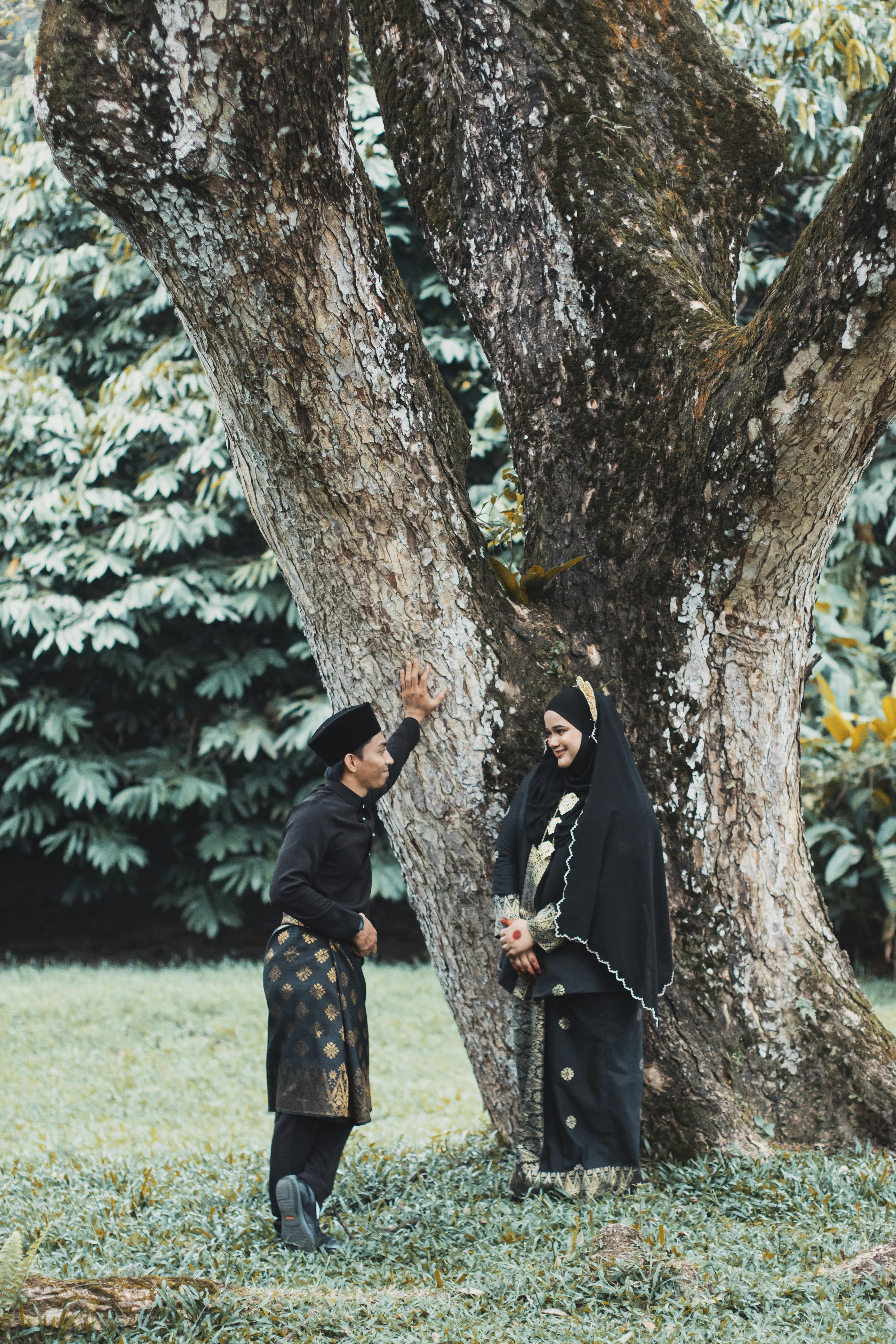 Couple in Traditional Clothes Talking Under a Tree · Free Stock Photo