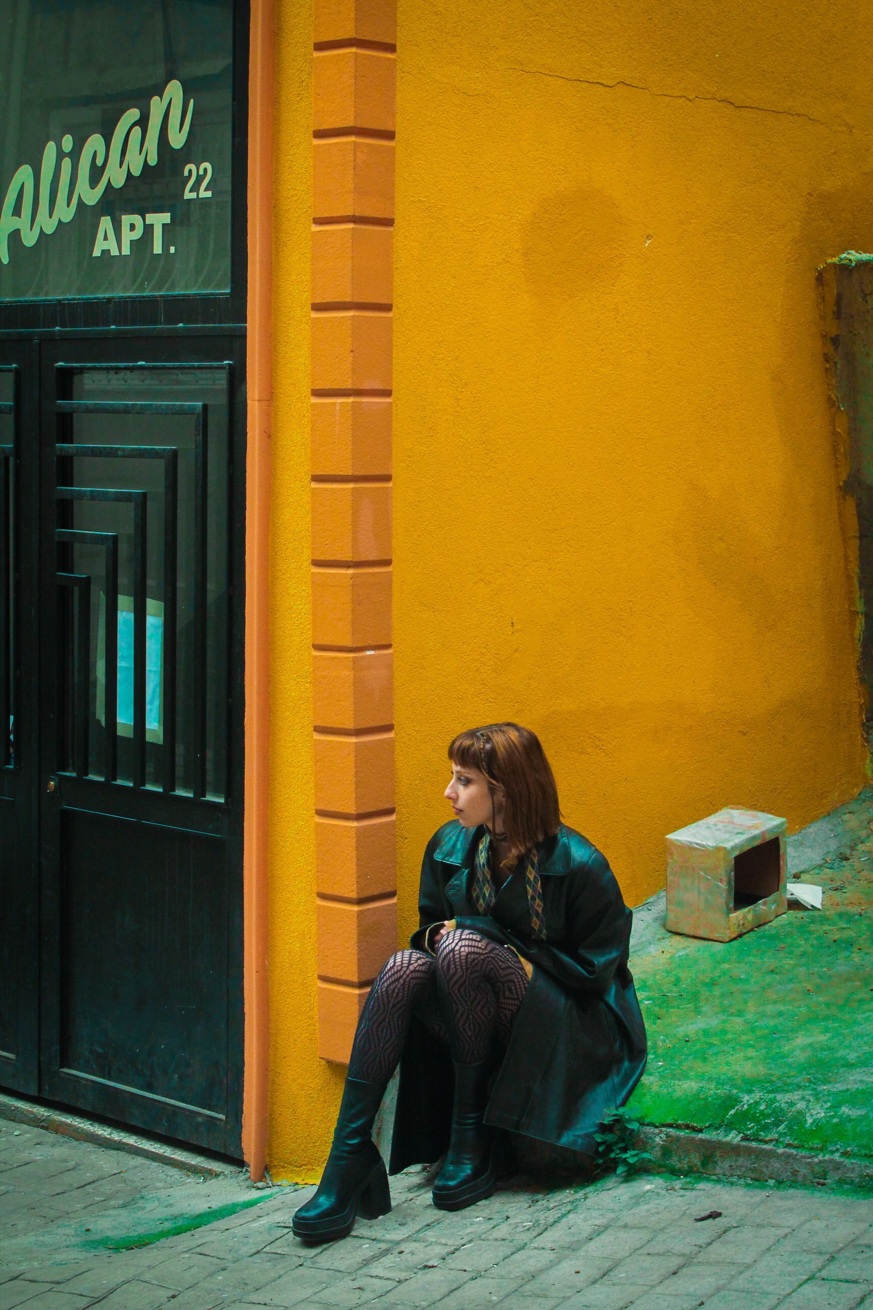 Woman Sitting on Ground on City Street · Free Stock Photo