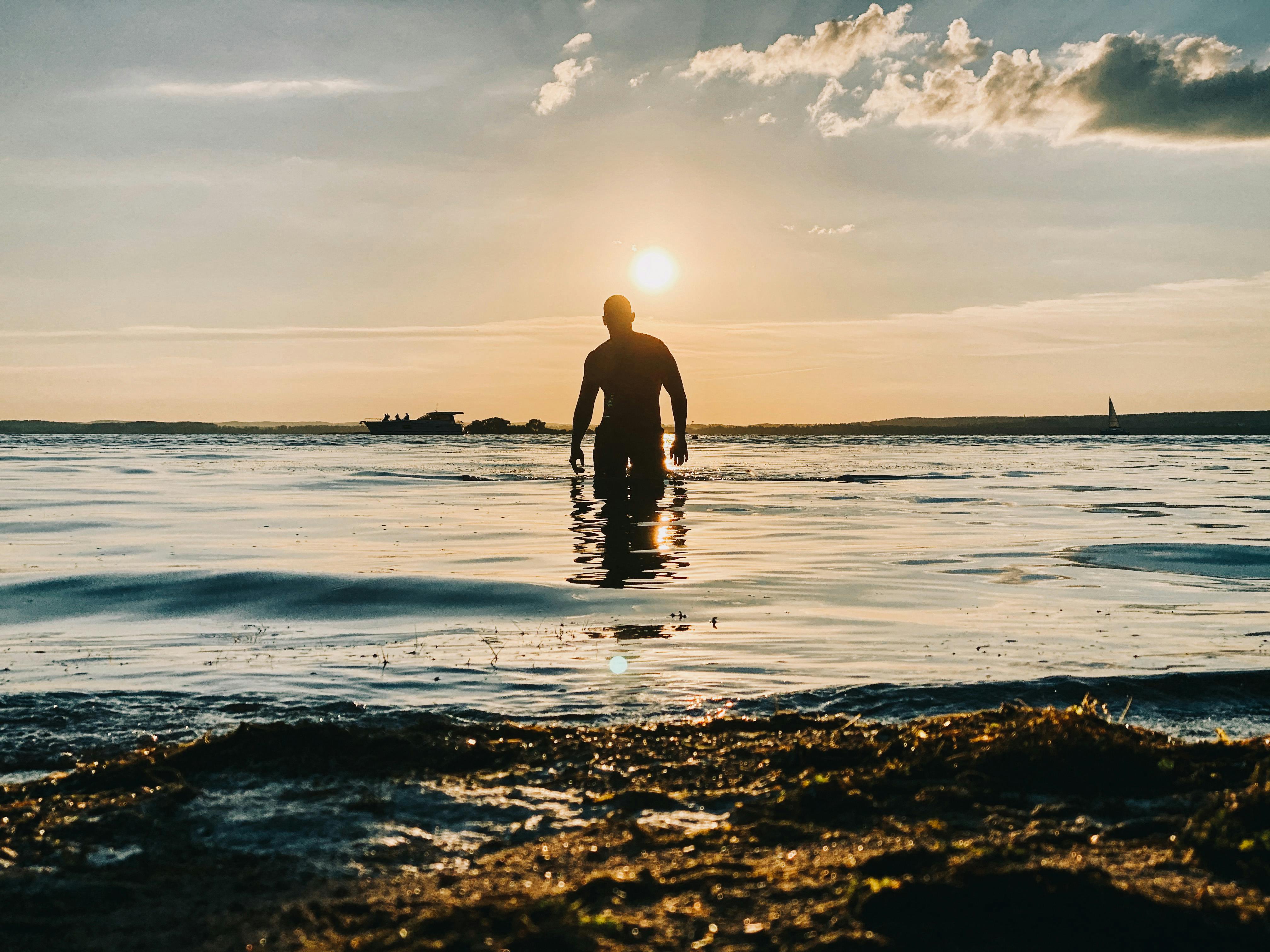 Silhouette of Man Walking out of Lake · Free Stock Photo