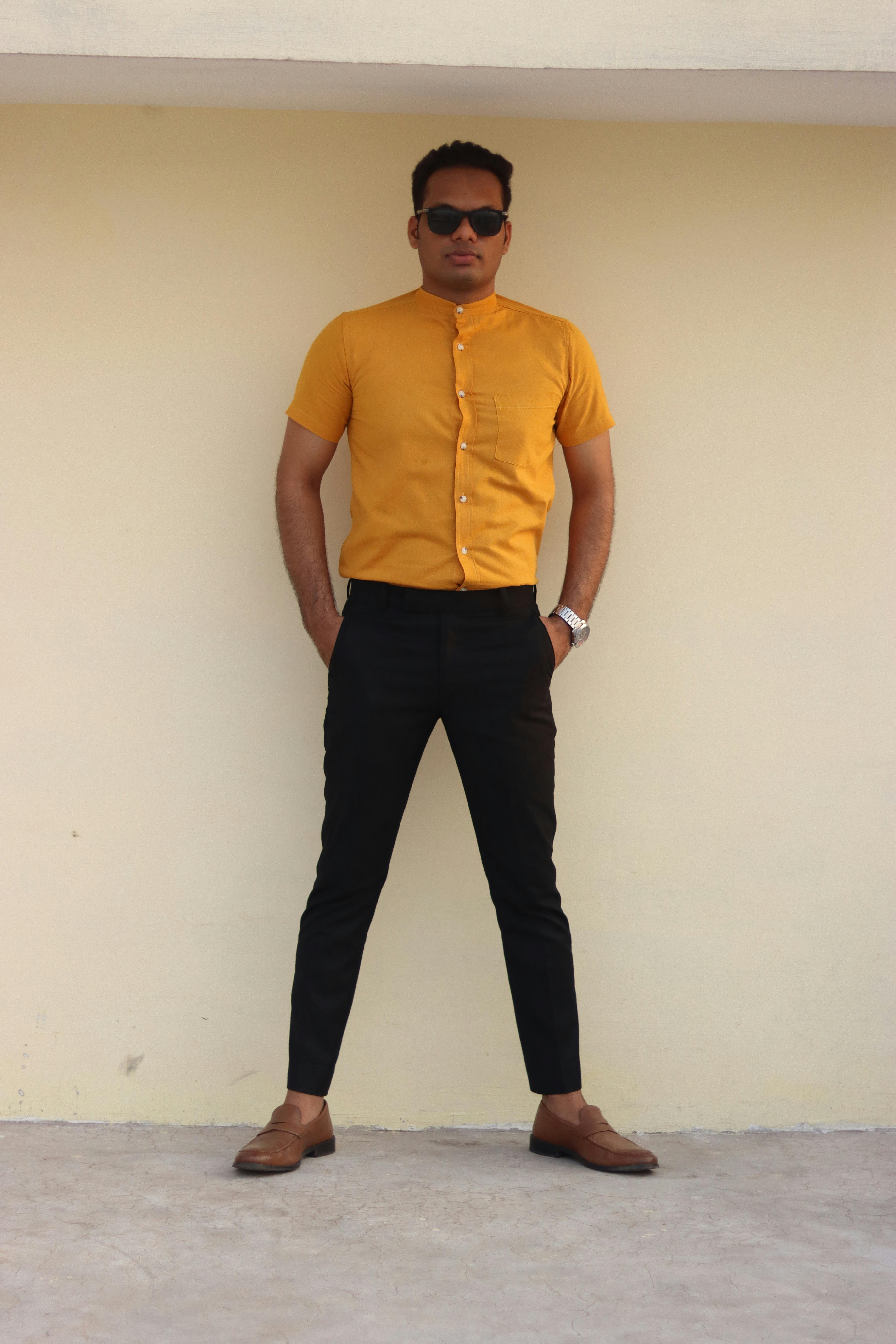 Man in Yellow Shirt Standing under Wall · Free Stock Photo