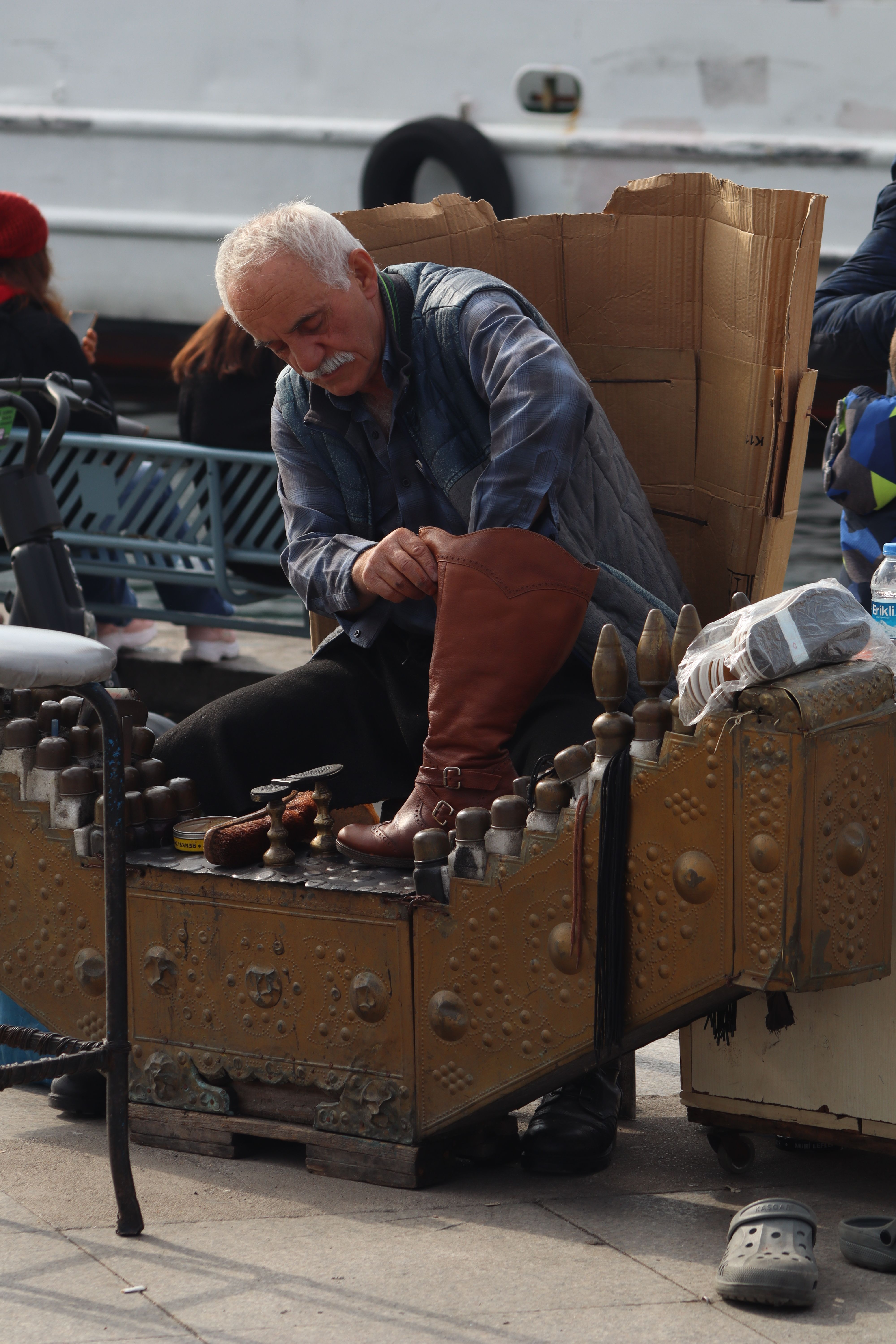Bootblack Sitting and Working · Free Stock Photo