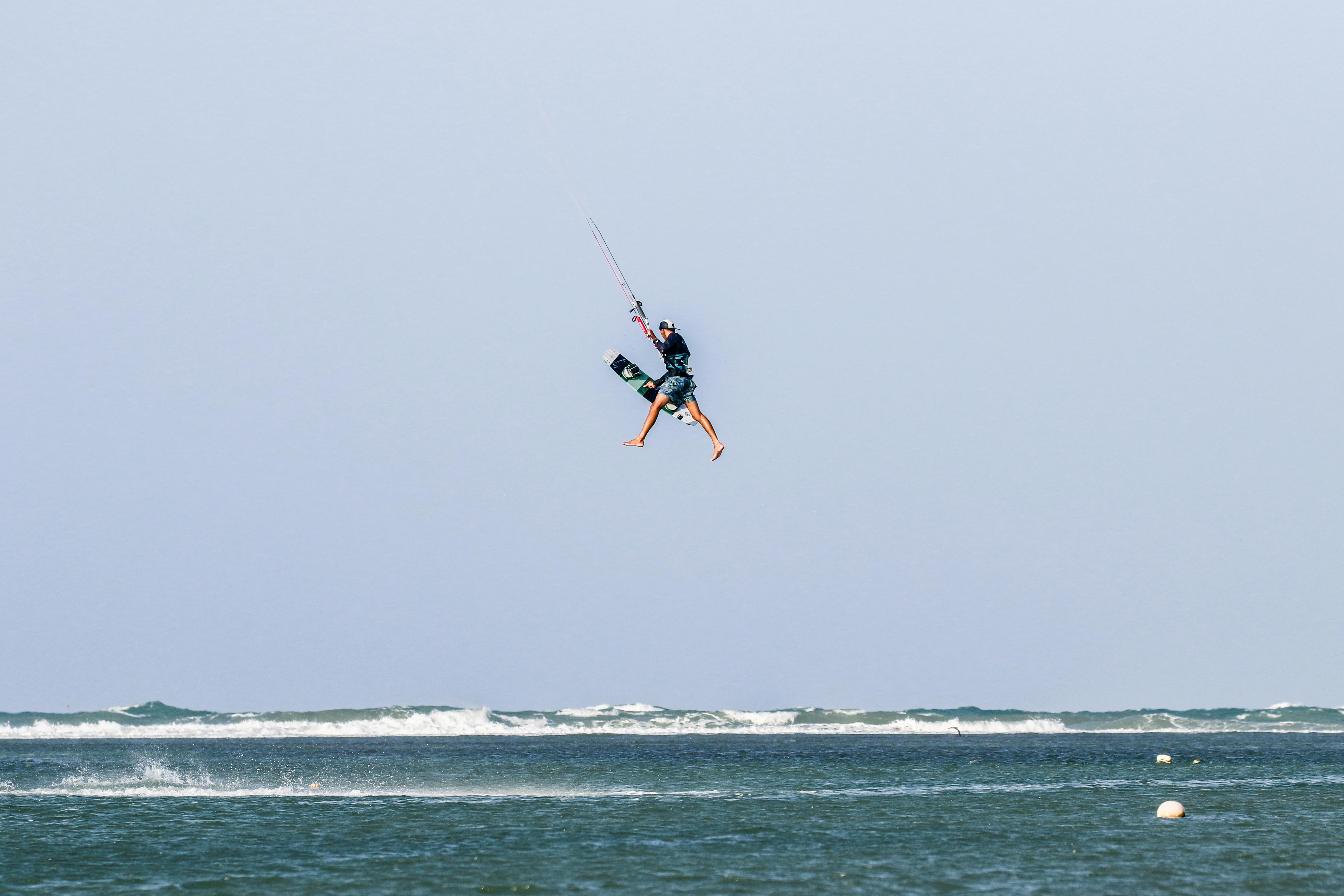 Man in Black Cap Sitting Between Two Hang Gliders on the Beach · Free ...