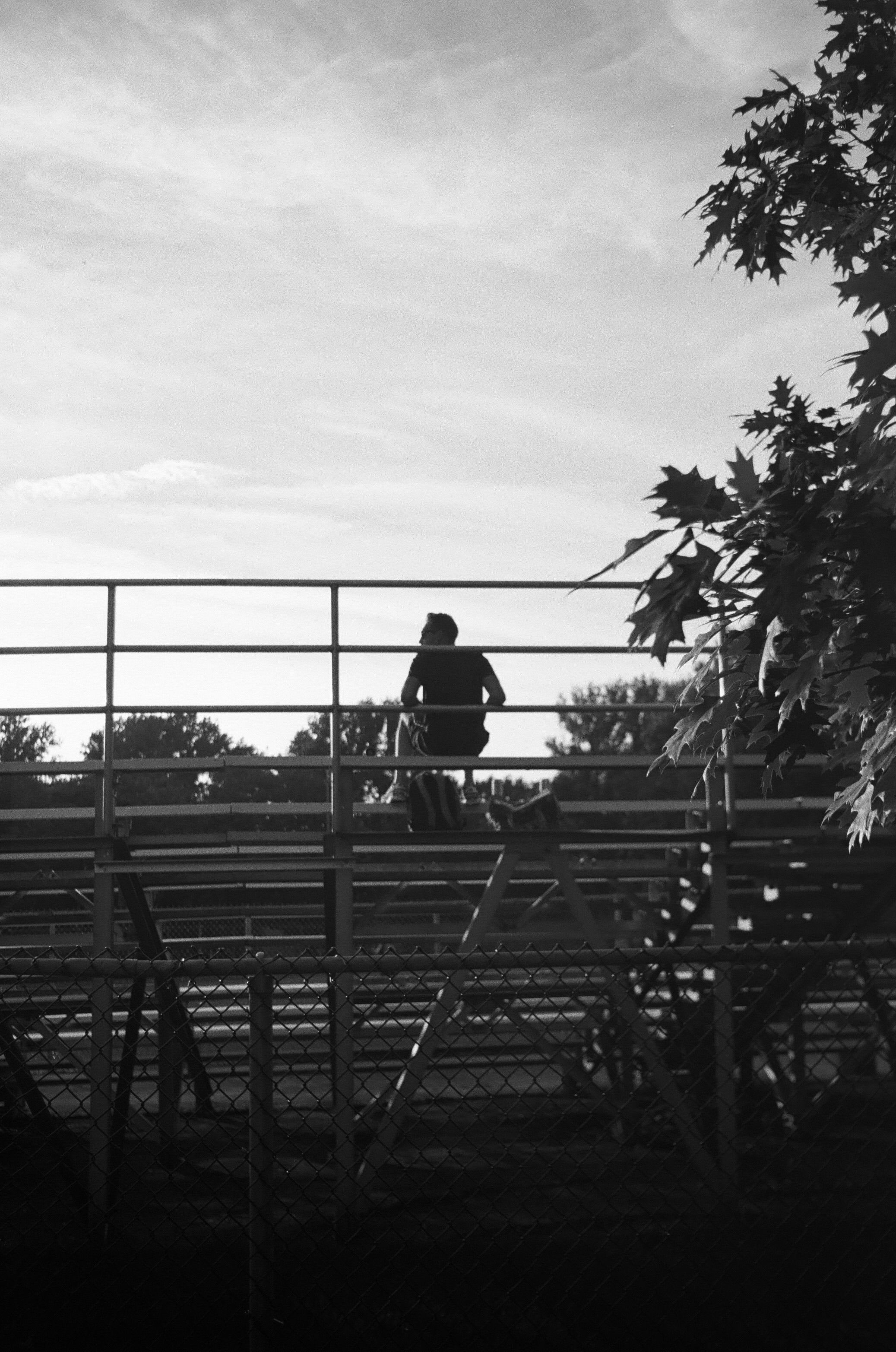 Person Sitting on Stadium Stand in Black and White · Free Stock Photo
