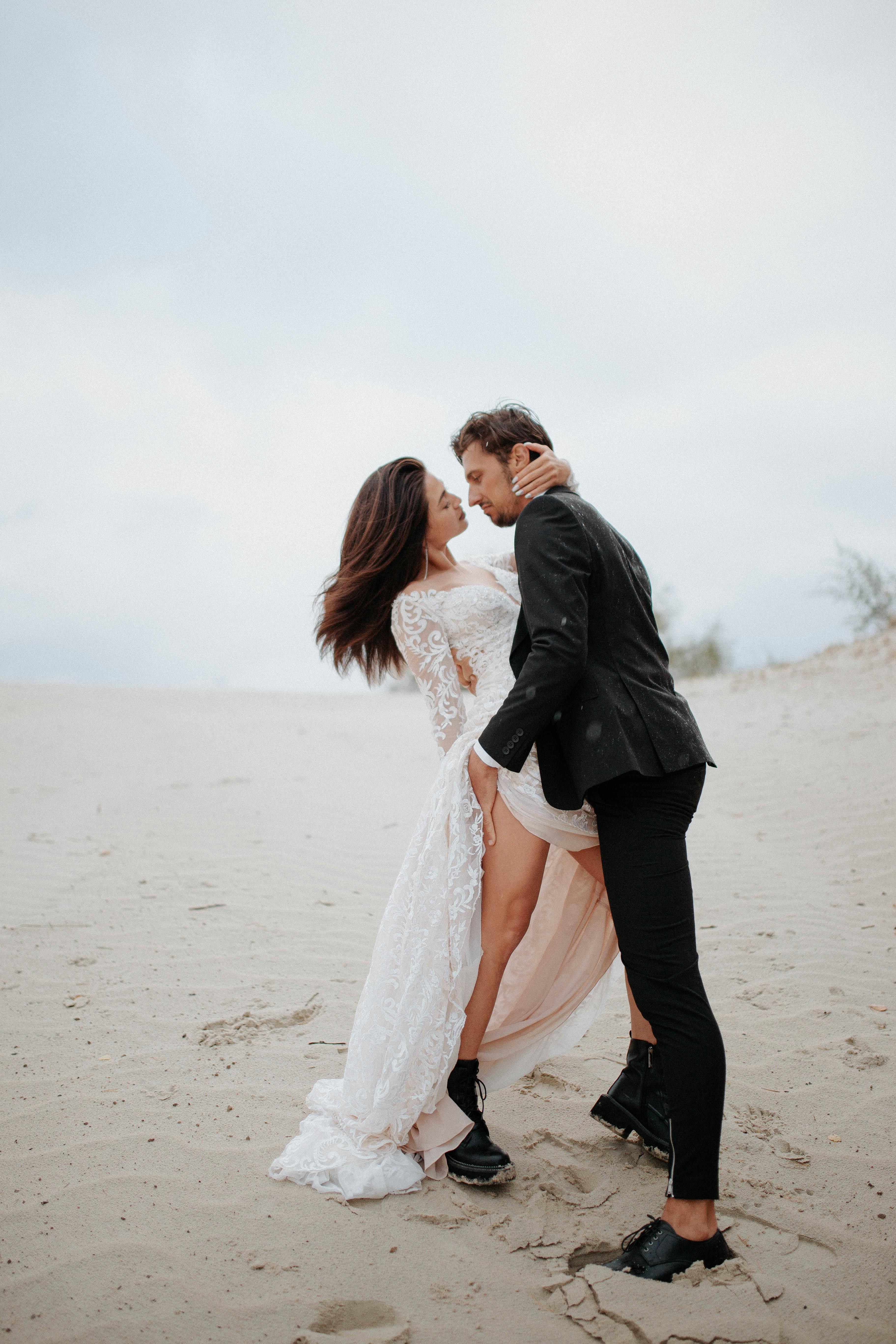 Bride and Groom Standing on the Beach and Hugging · Free Stock Photo