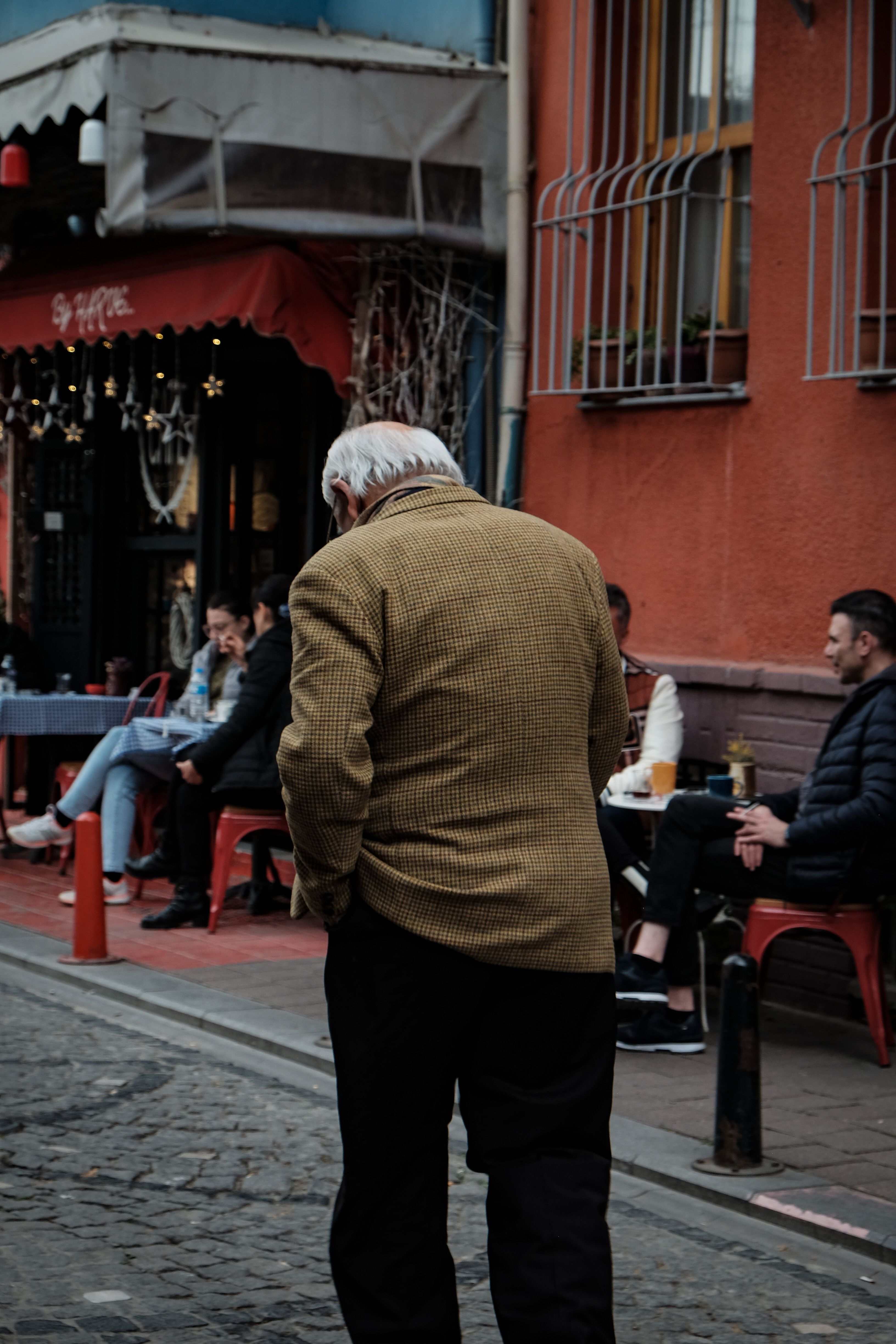 Elderly Man Walking on Paving Stone Street · Free Stock Photo