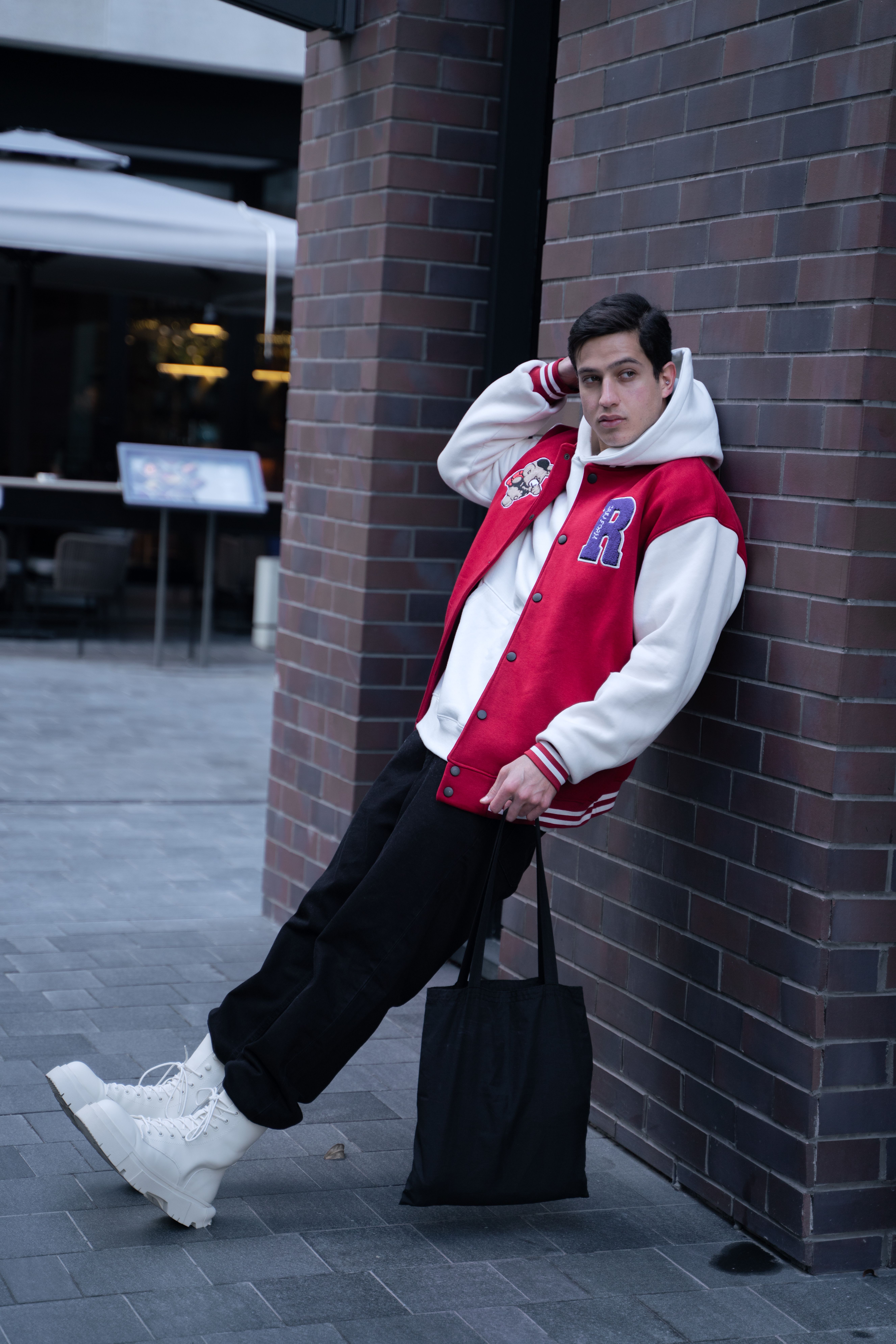 Young Man in Bomber Jacket Posing near Brick Wall · Free Stock Photo
