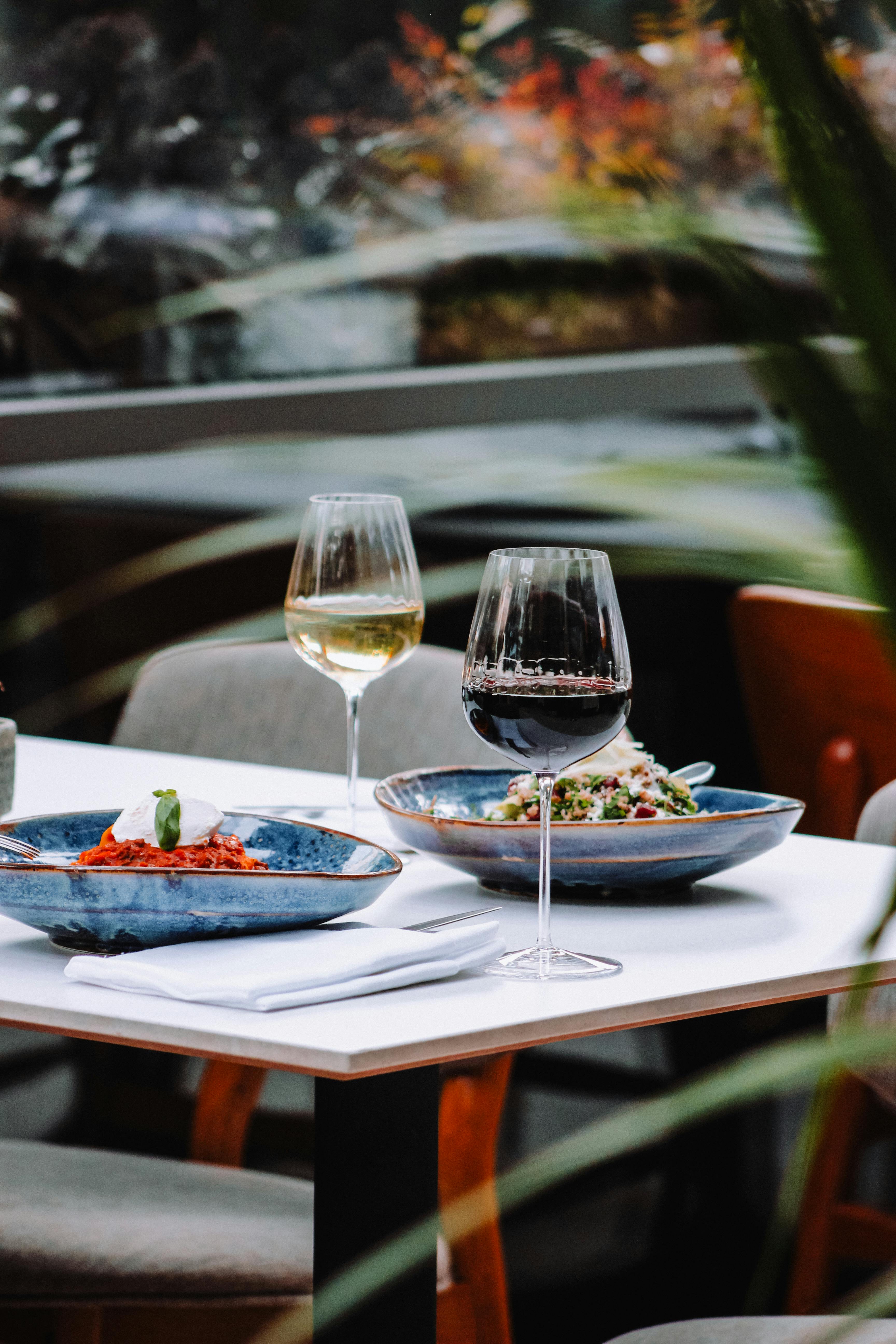 Plates of Food and Wine Glasses on a Table · Free Stock Photo