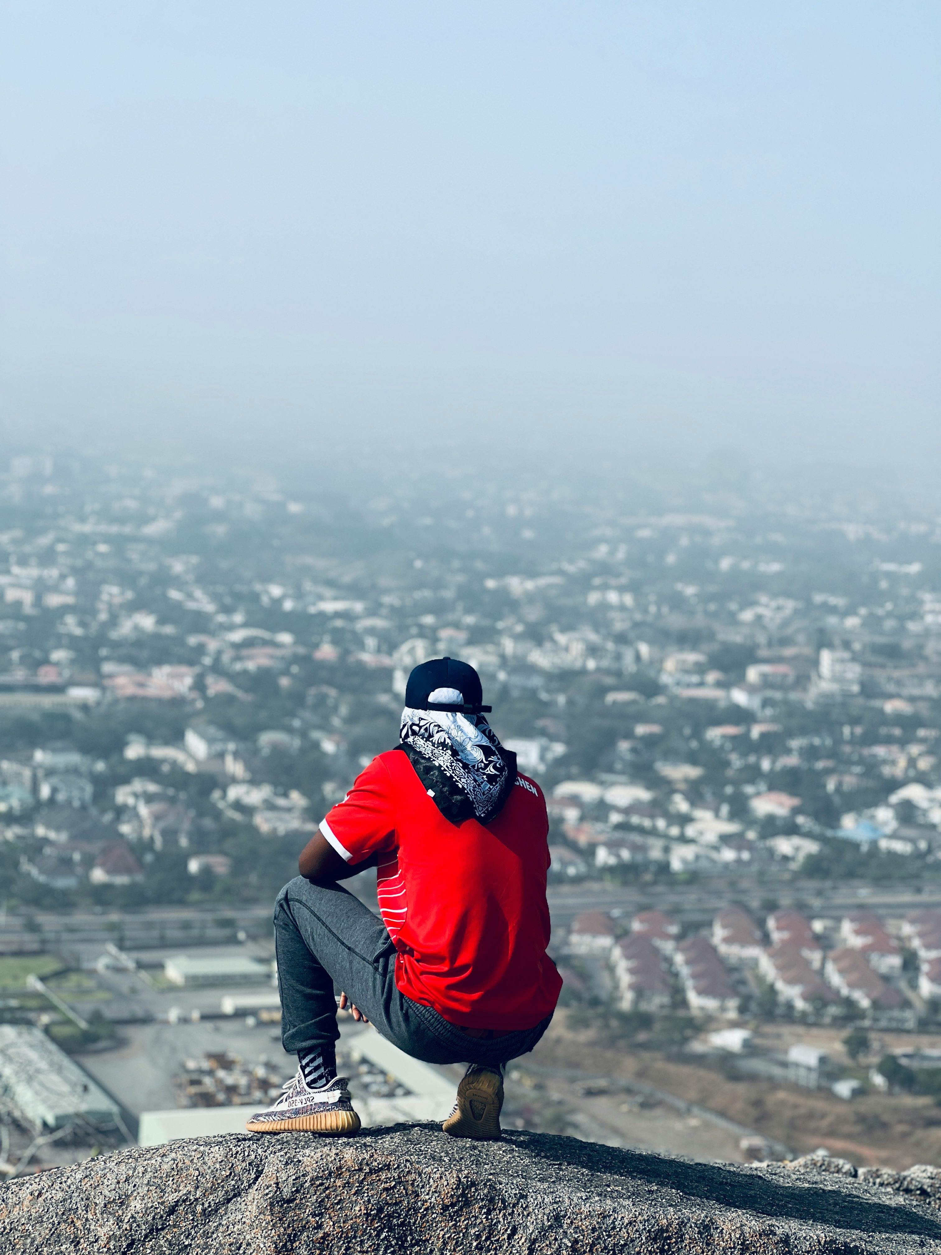 A Man Looking at The City from a Mountain · Free Stock Photo