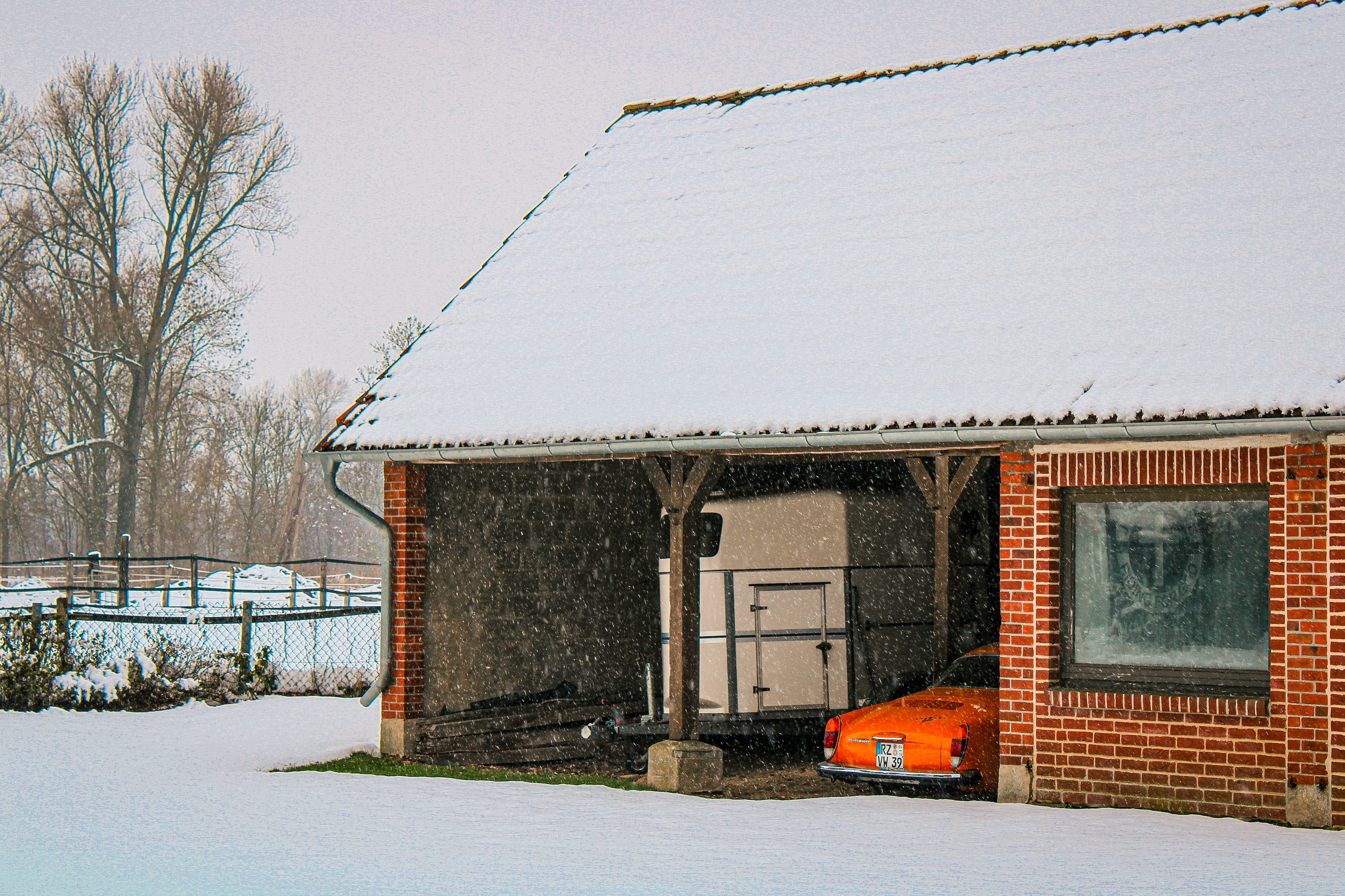 Classic Car in Garage of Red Brick House in Snowy Winter · Free Stock Photo