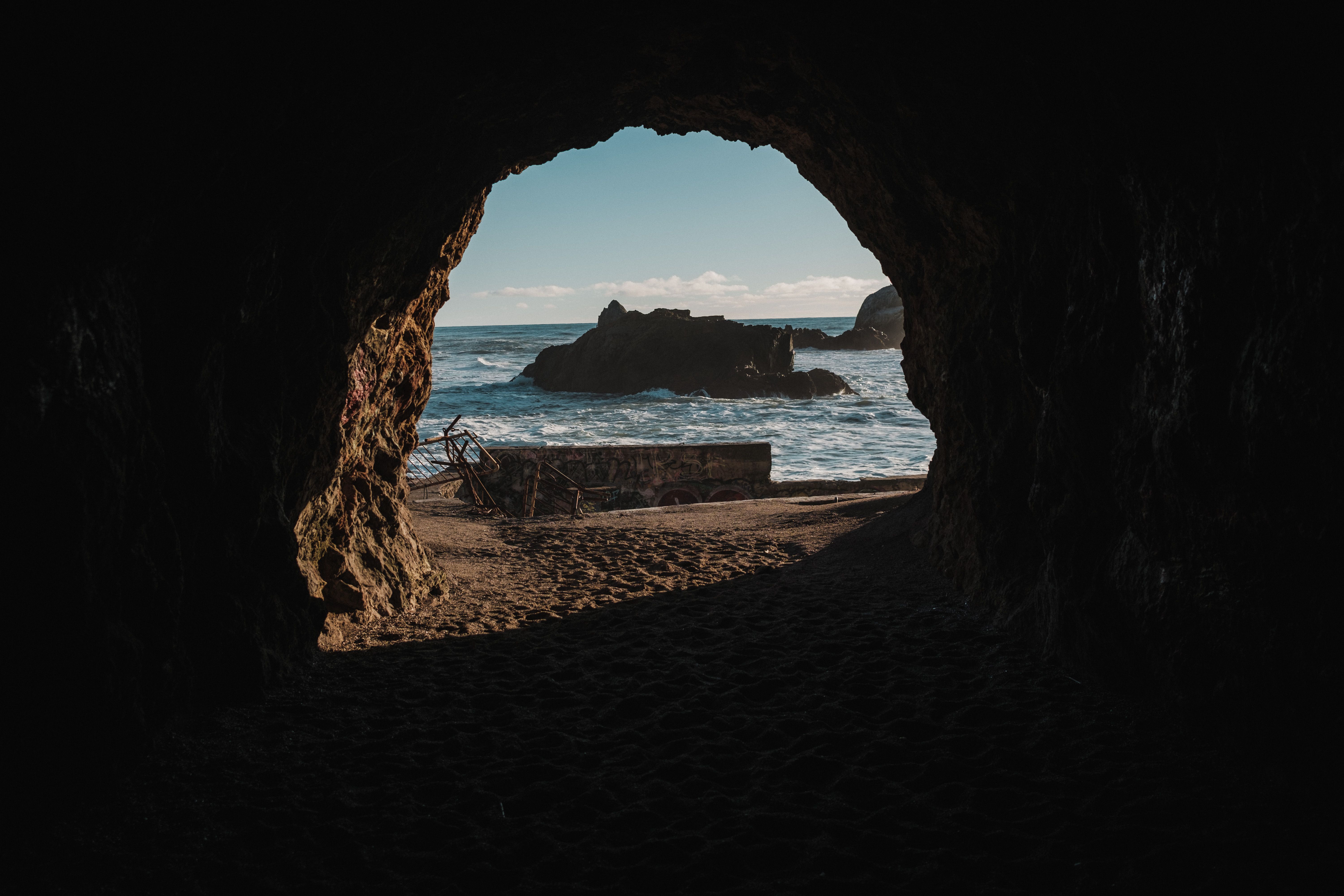 Back view Photo of Person Walking Out of a Cave · Free Stock Photo