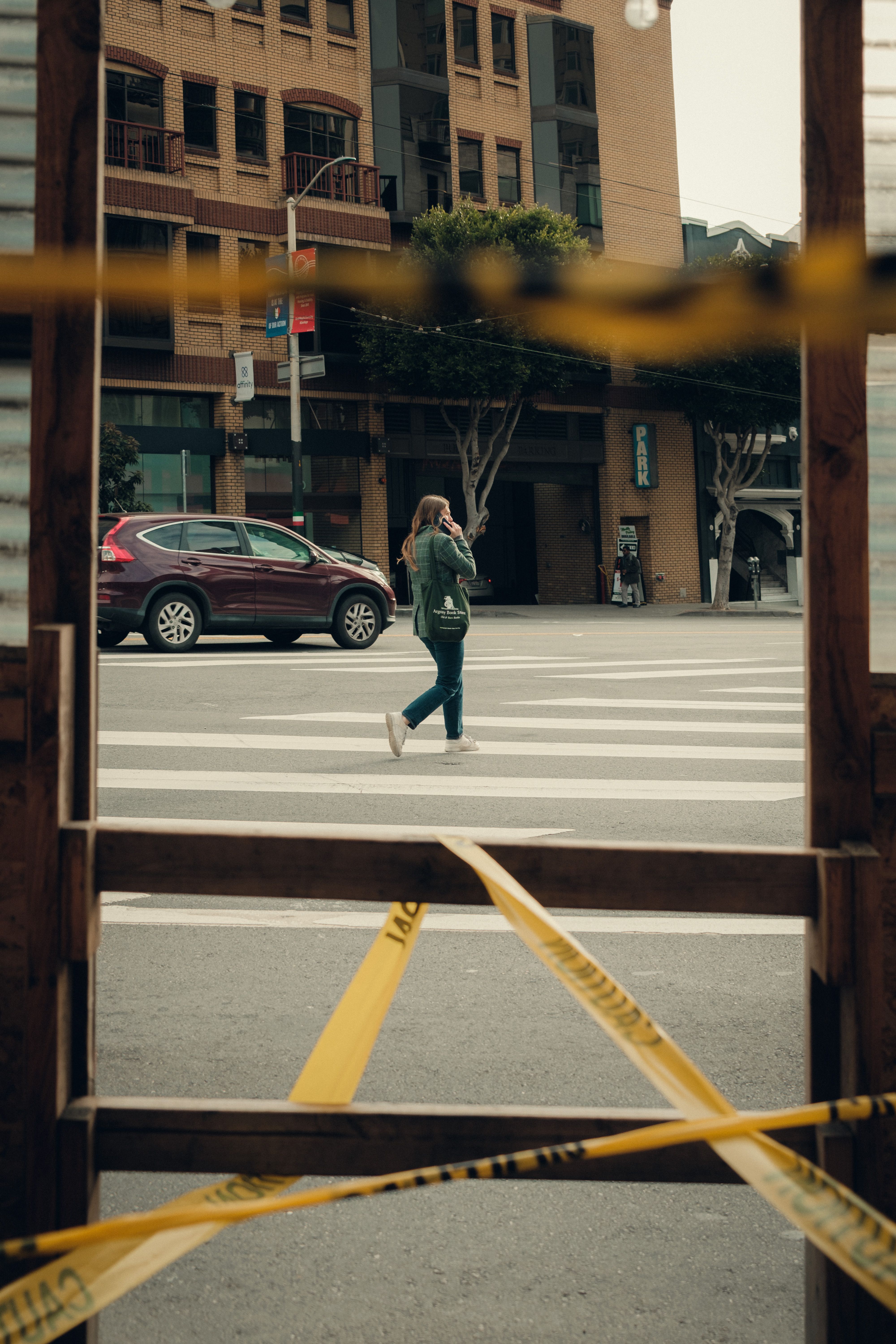 Woman Crossing Street behind Yellow Tape · Free Stock Photo