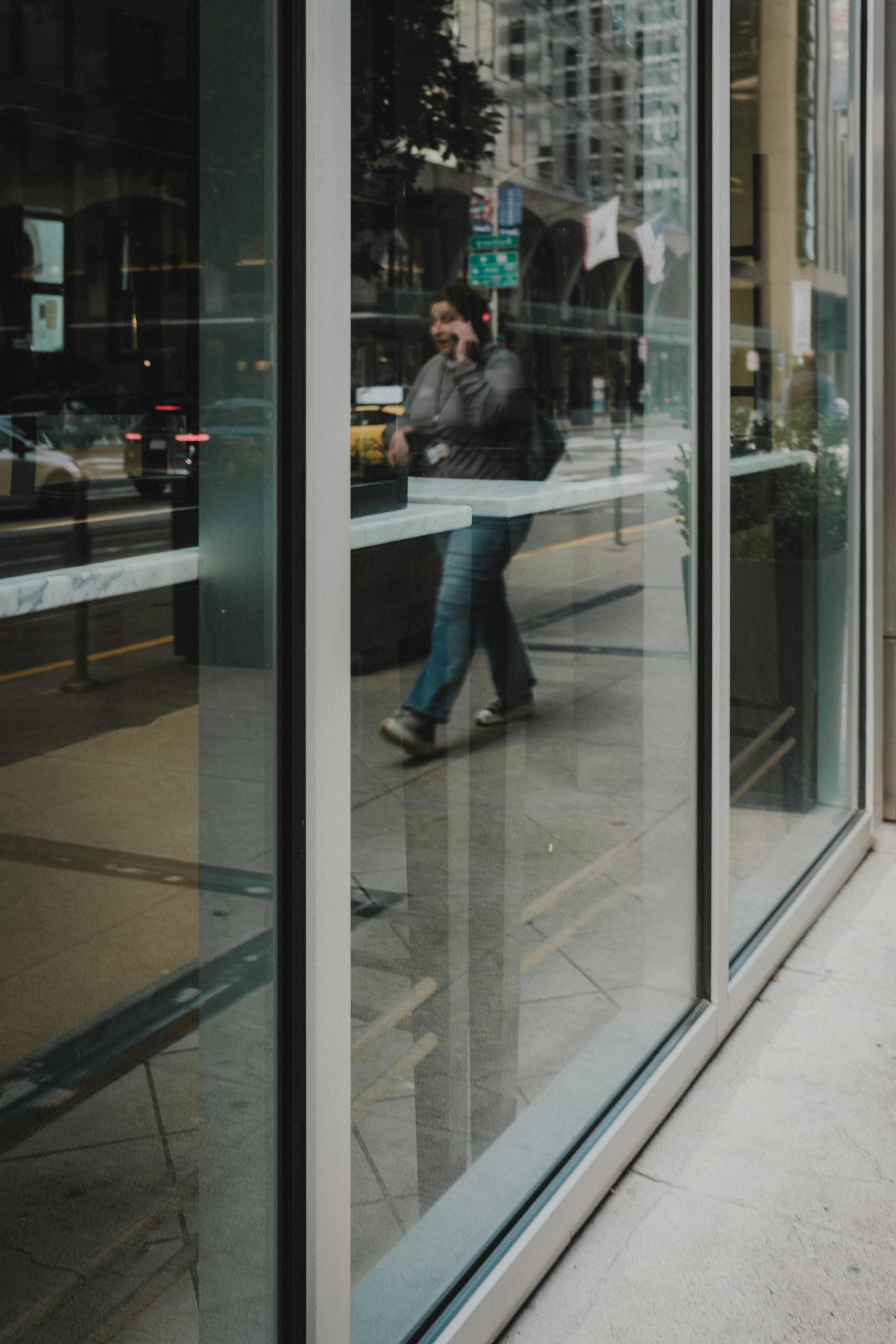 Reflection of Walking Woman in Window · Free Stock Photo