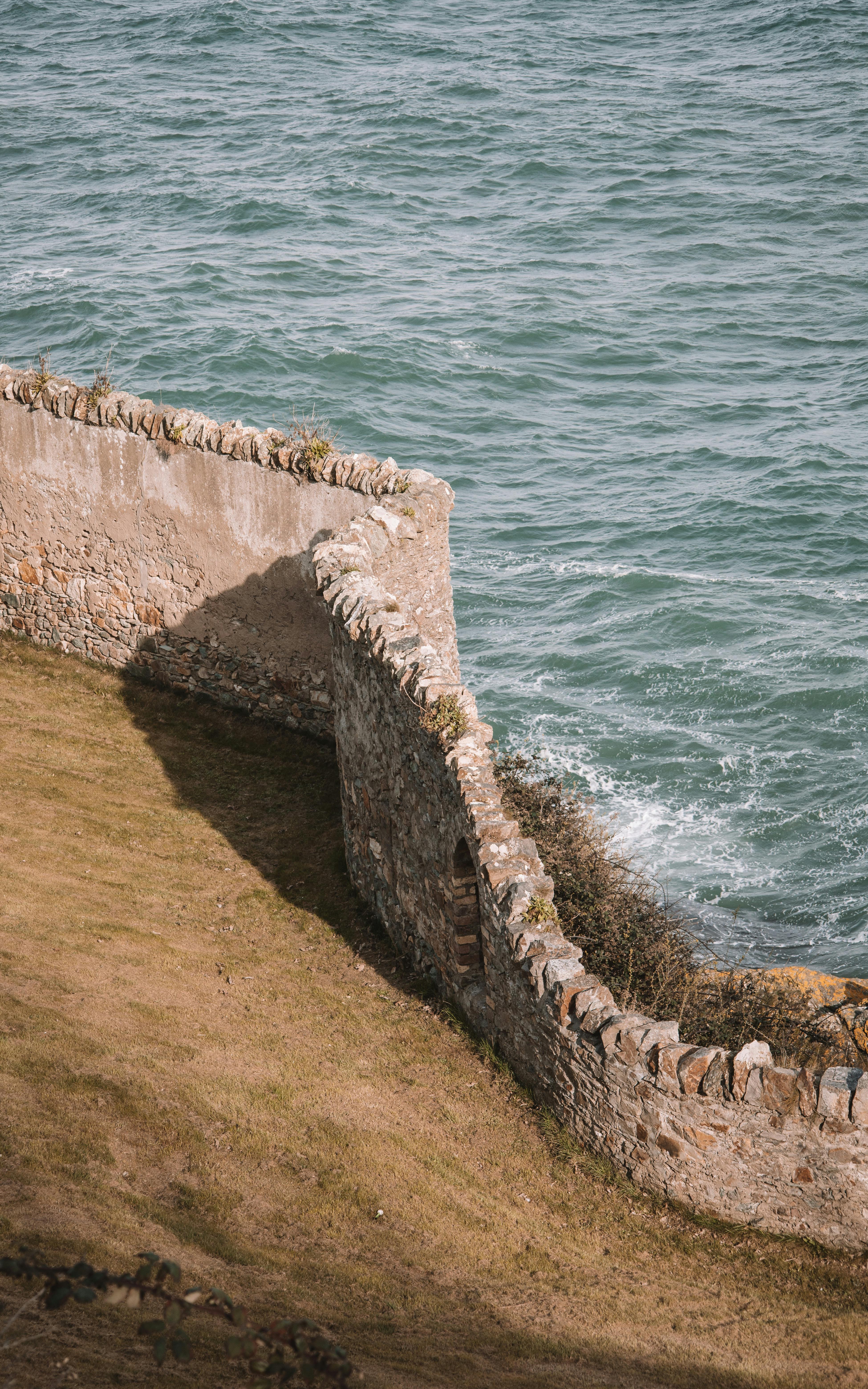 Photo of a Stone Wall Along Coastline · Free Stock Photo