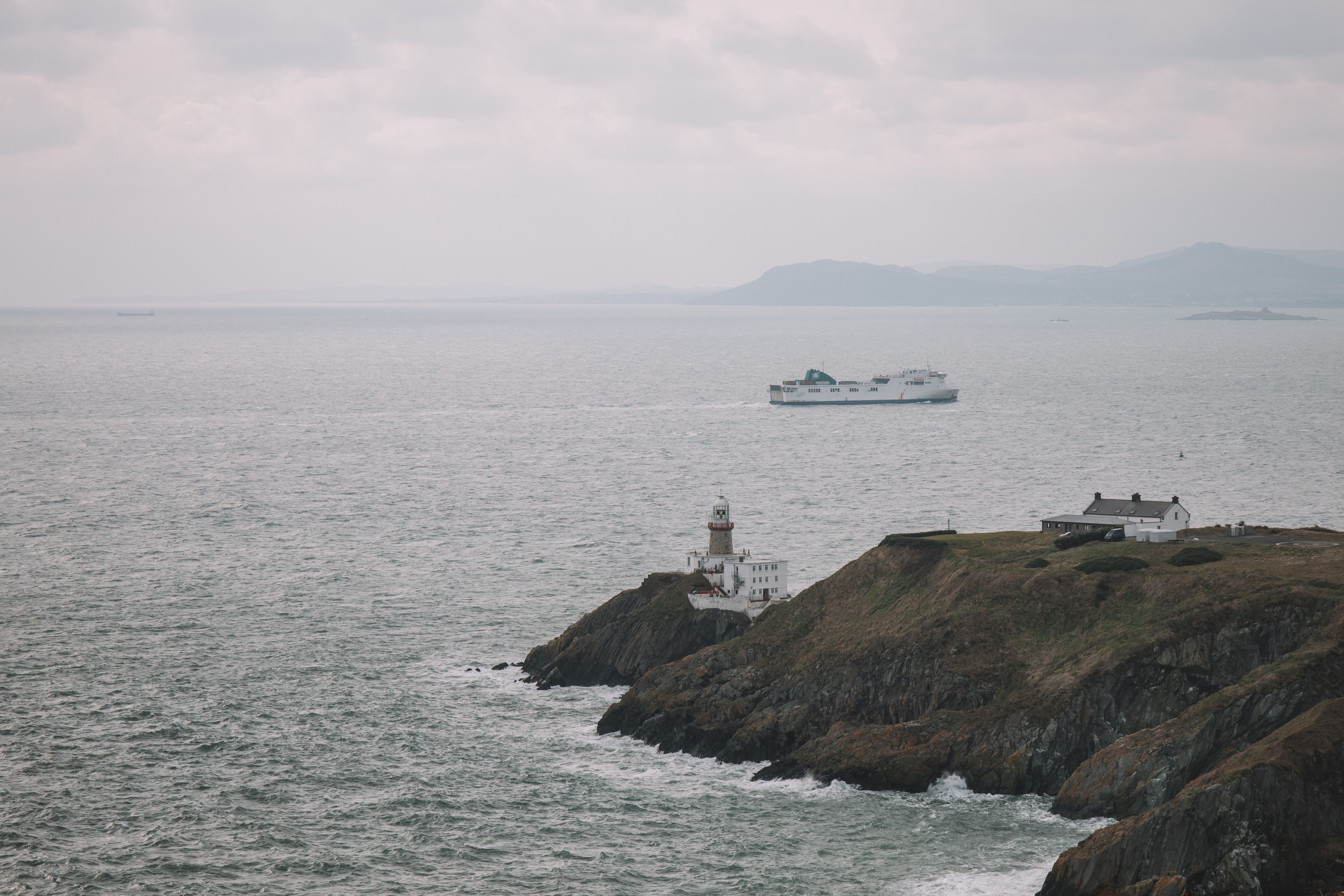 Lighthouse on Cliff in Sea · Free Stock Photo