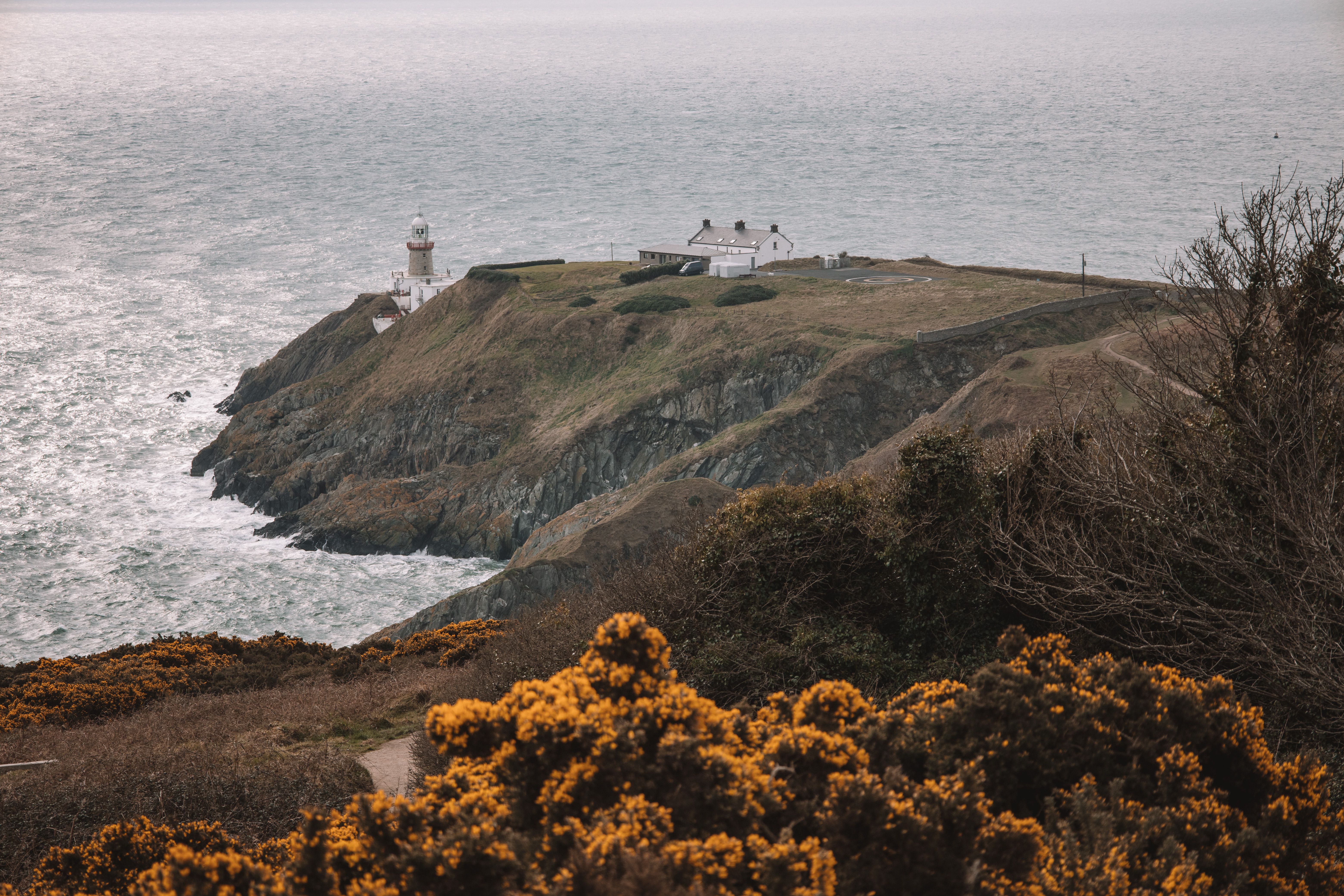 Lighthouse on Cliff at Seashore on Sunset · Free Stock Photo
