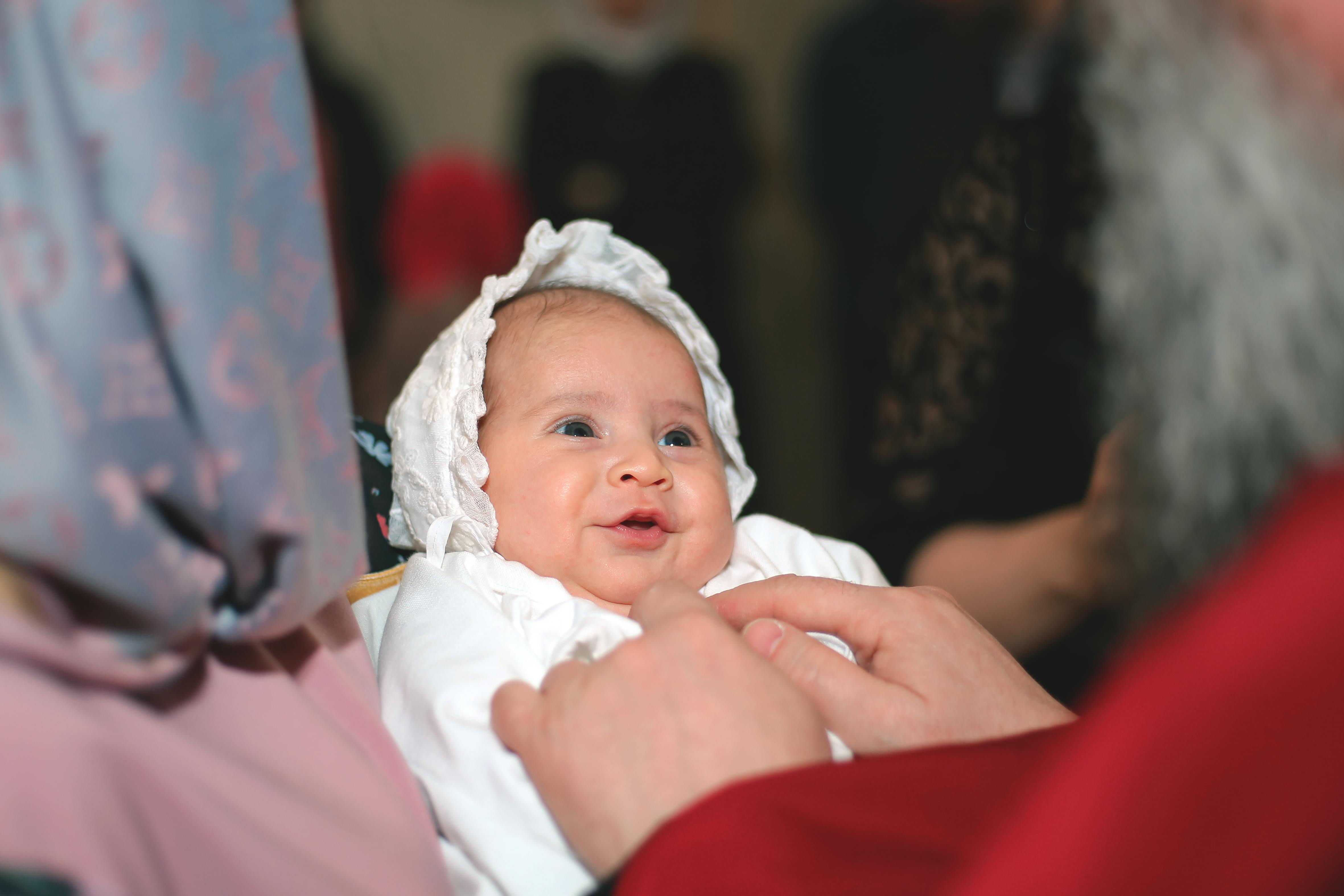 A Little Baby Smiling during Baptism · Free Stock Photo
