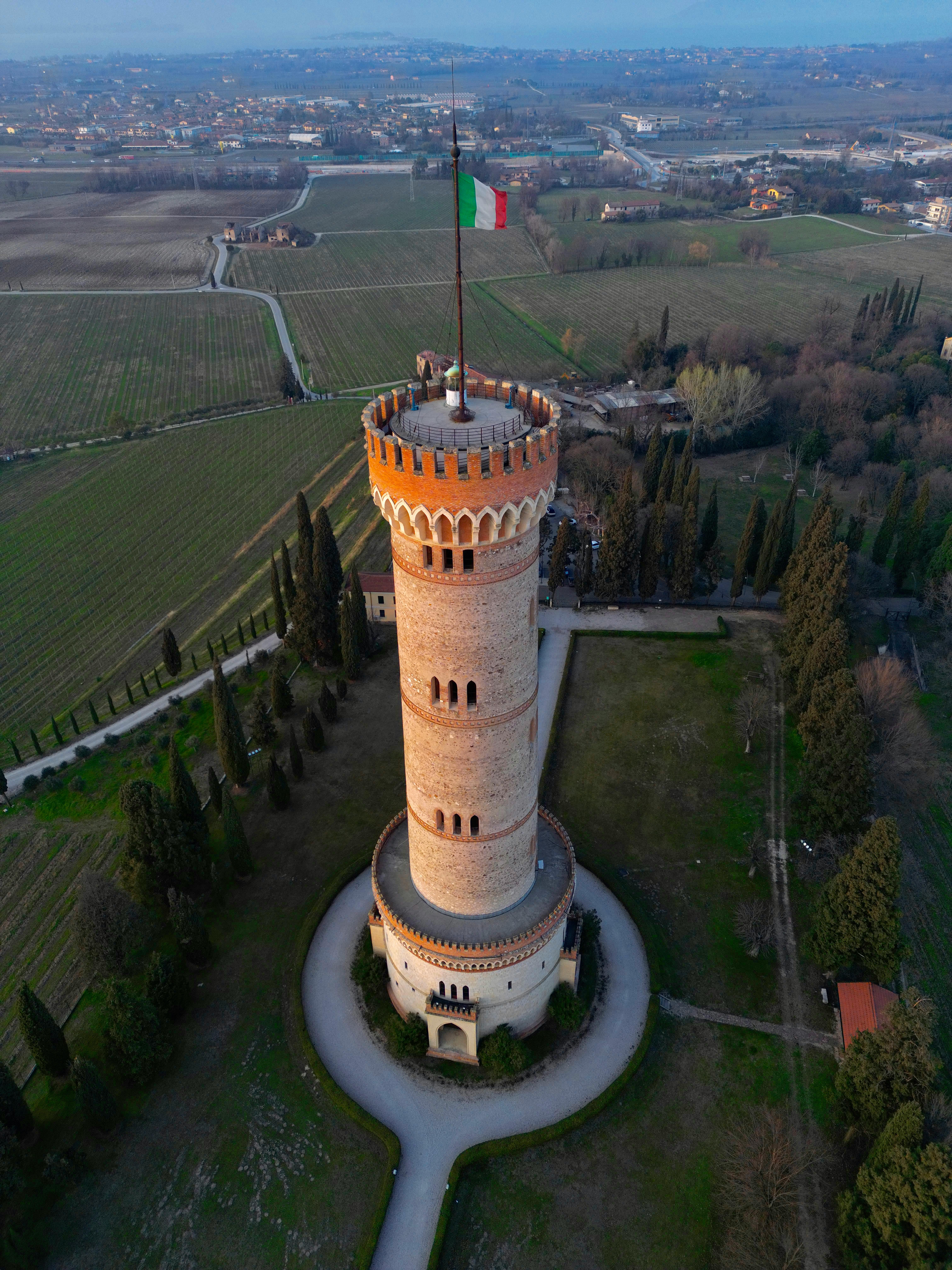 Country Flag on Brick Tower in Countryside · Free Stock Photo