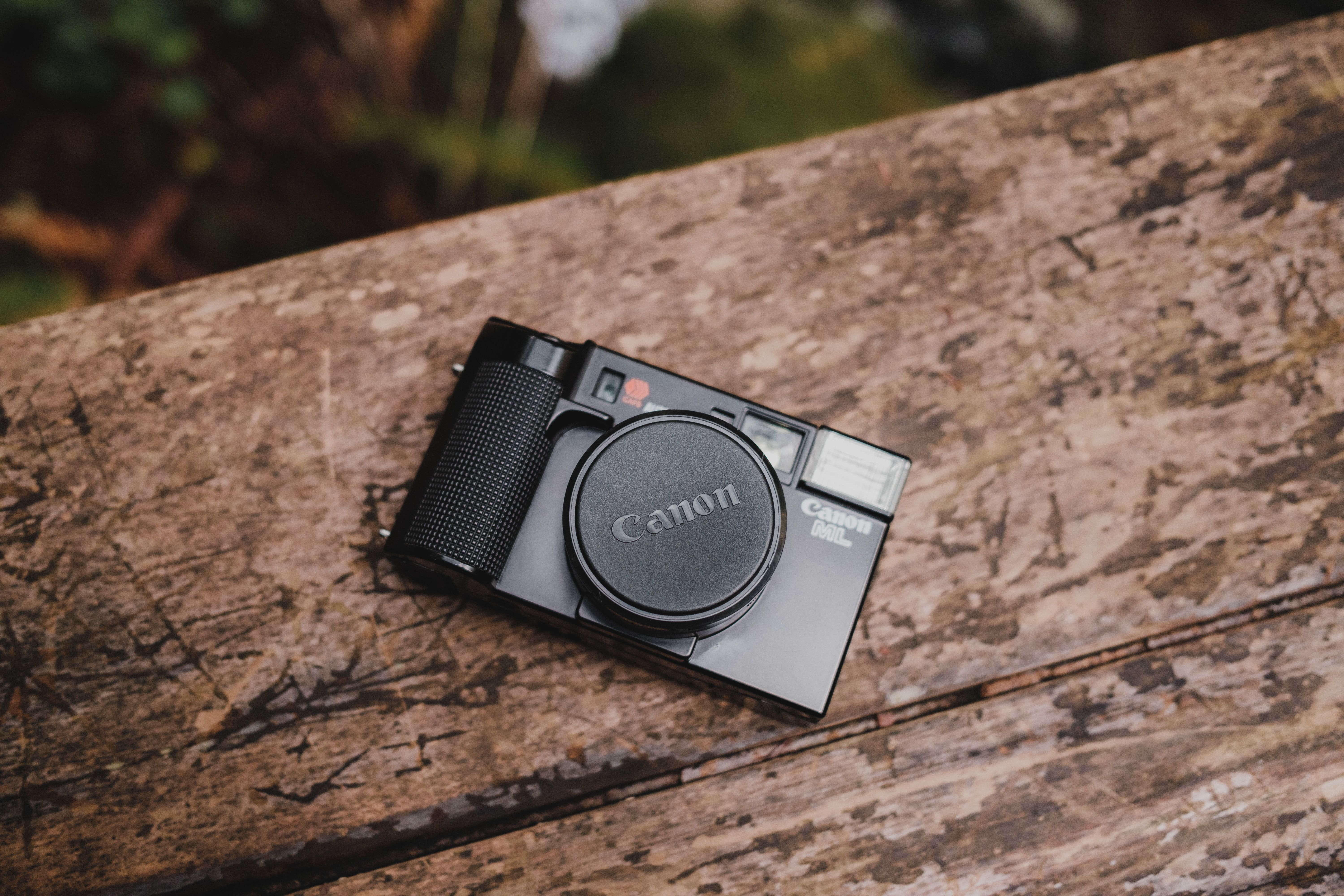 A black camera sitting on top of a wooden table · Free Stock Photo