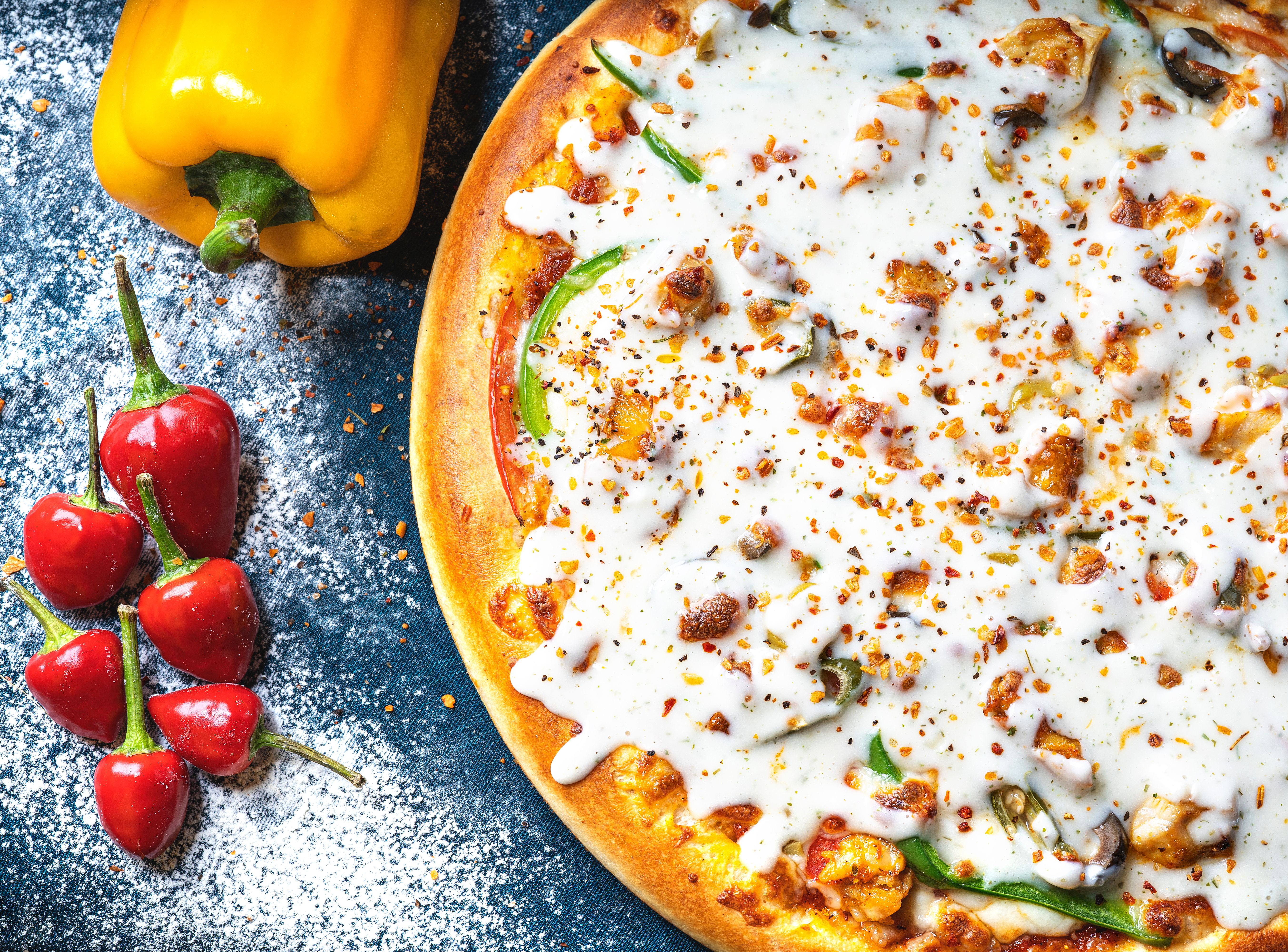 A Pizza Covered with White Sauce and Fresh Peppers on a Table · Free ...