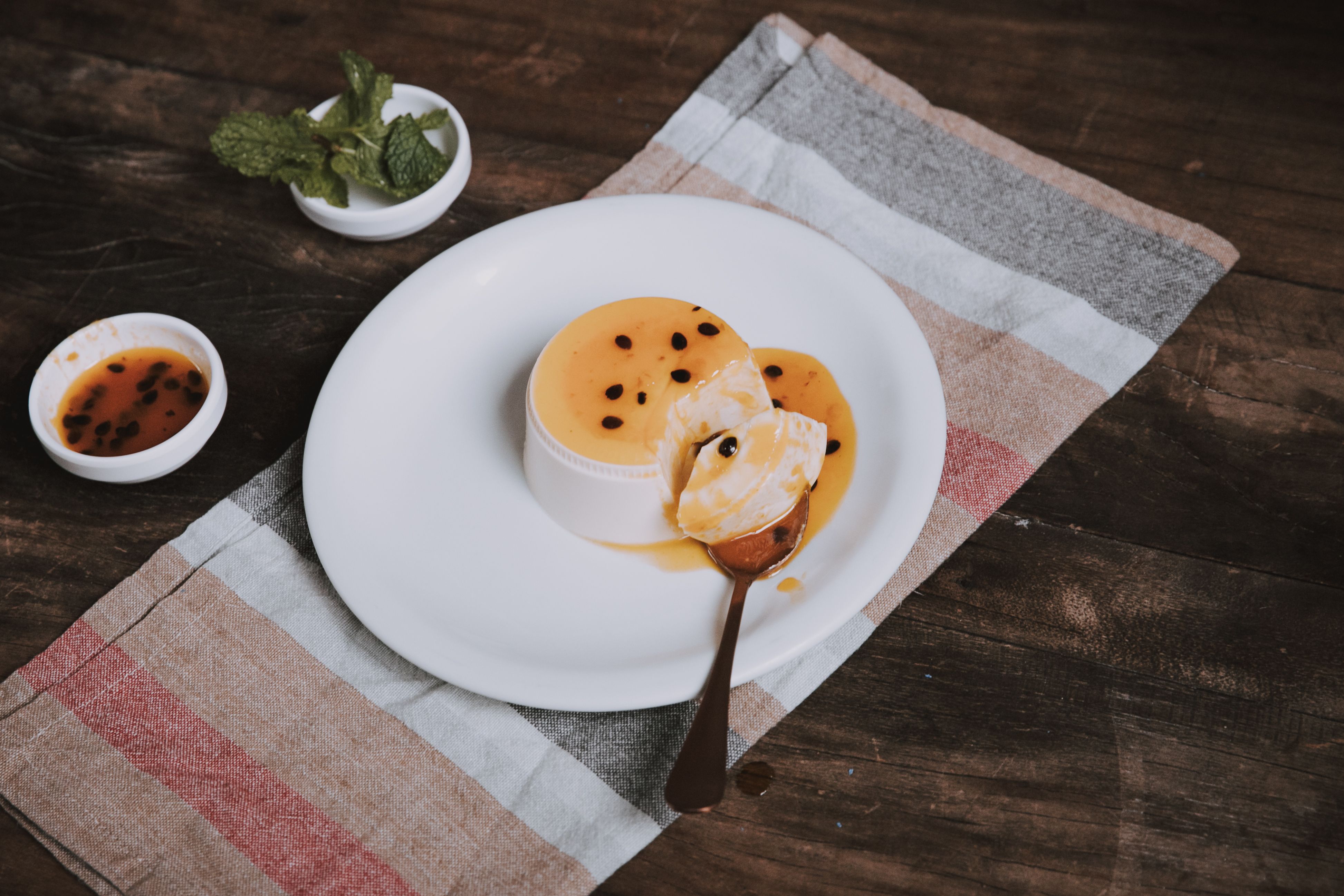 Flan Dessert with Passion Fruit Sauce on a Plate, and Striped Tea Towel ...