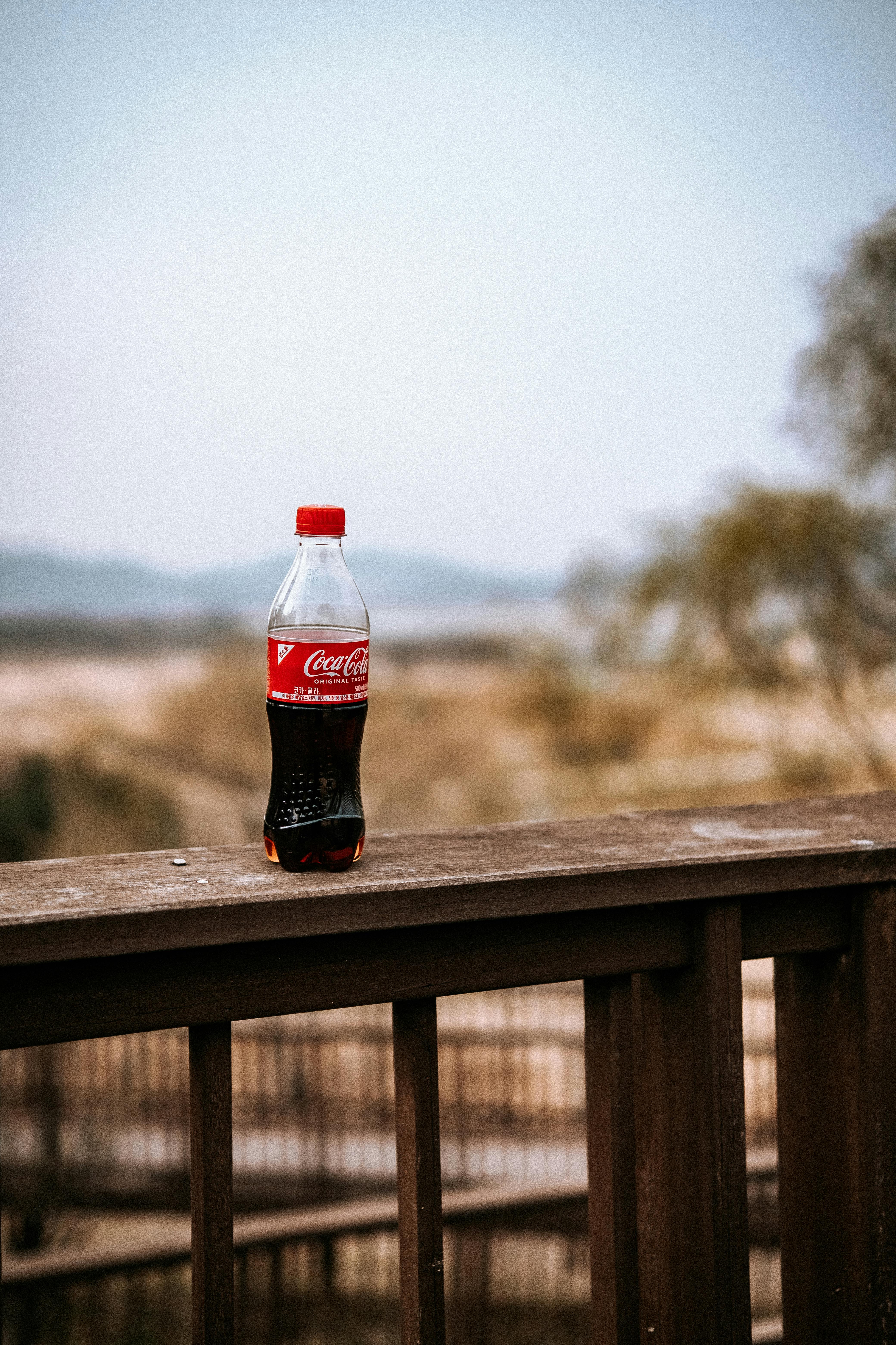 Coca Cola Bottle on Wooden Handrail · Free Stock Photo
