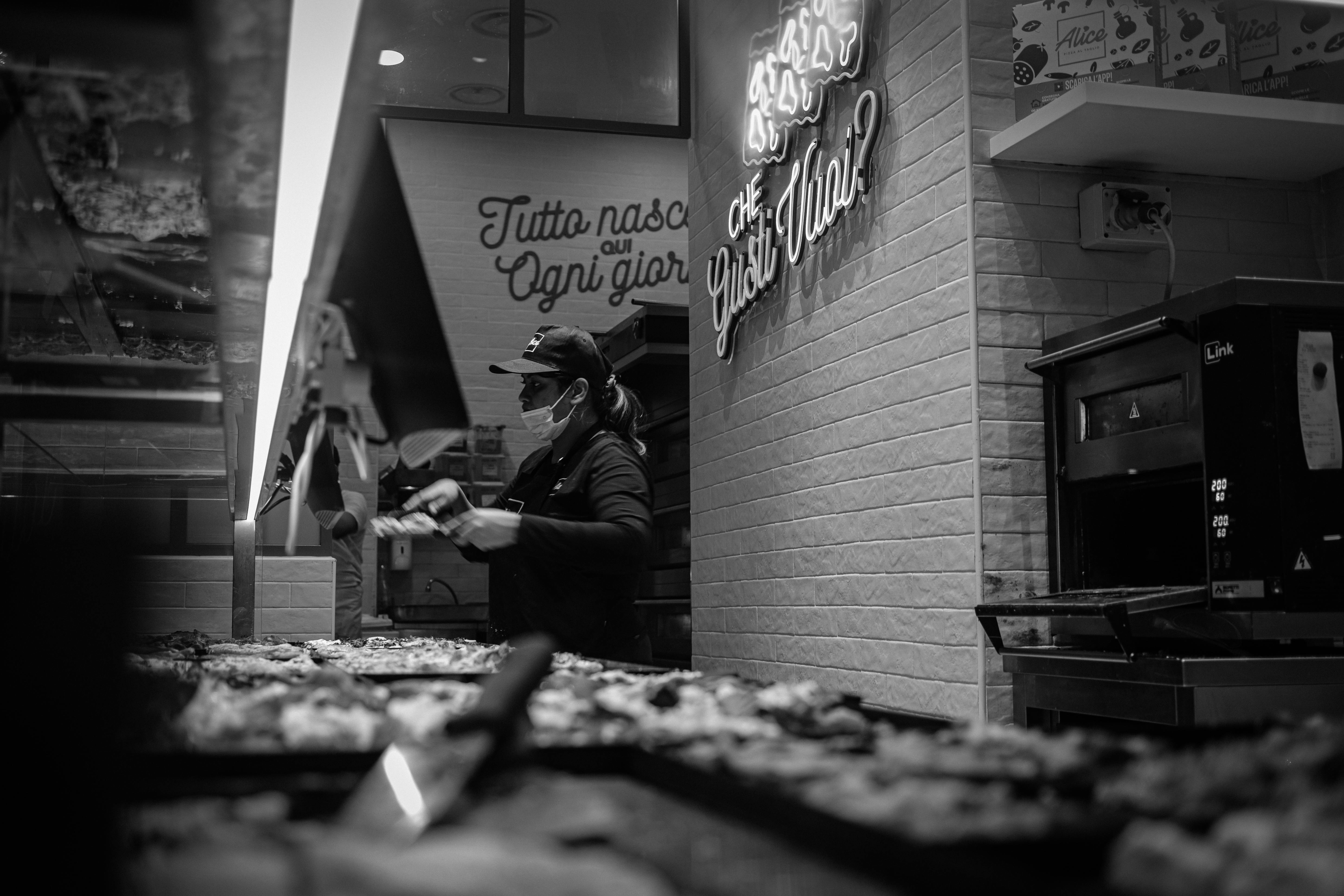 A black and white photo of a man standing in front of a counter · Free ...