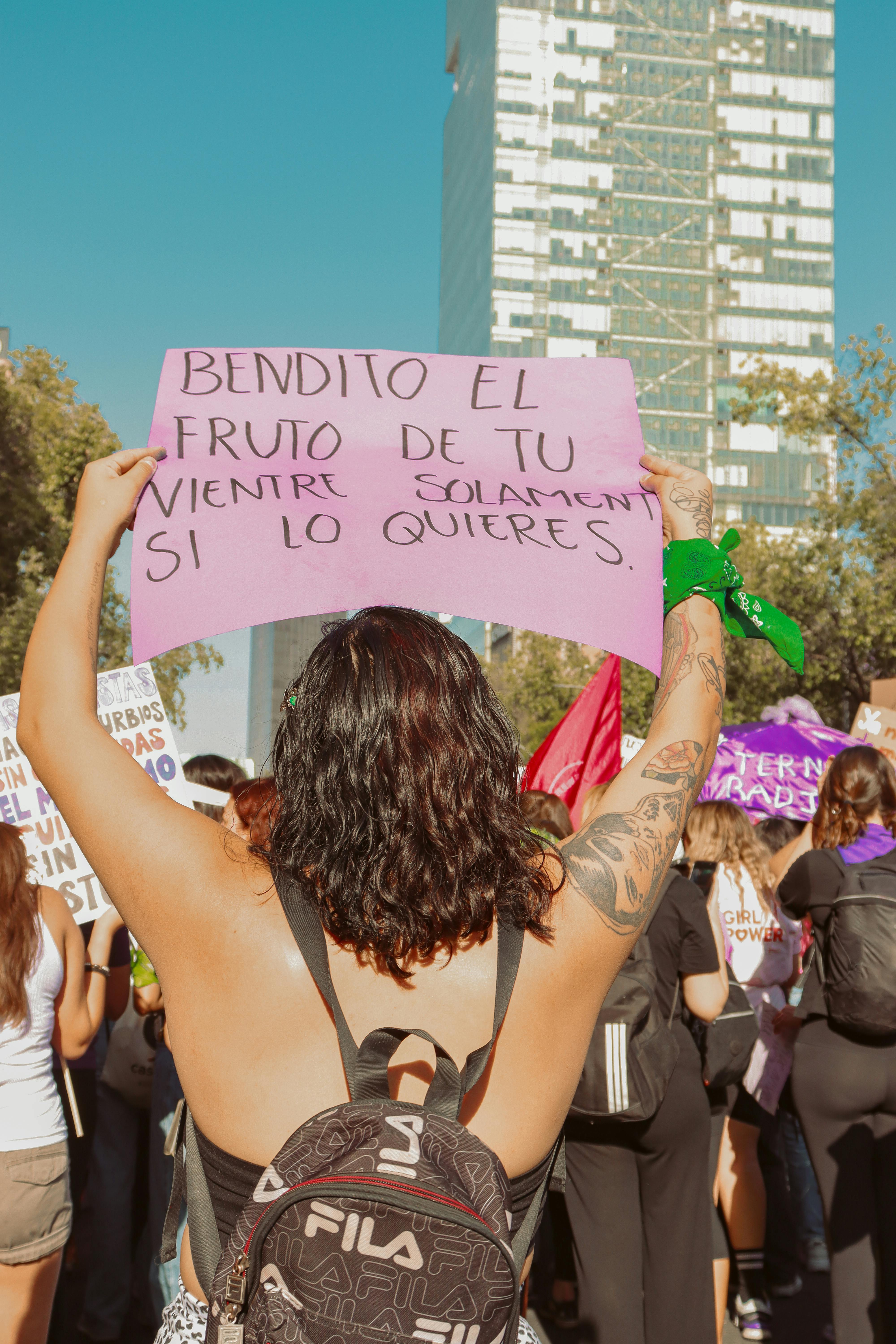 Woman Holding Up Purple Board at Protest · Free Stock Photo