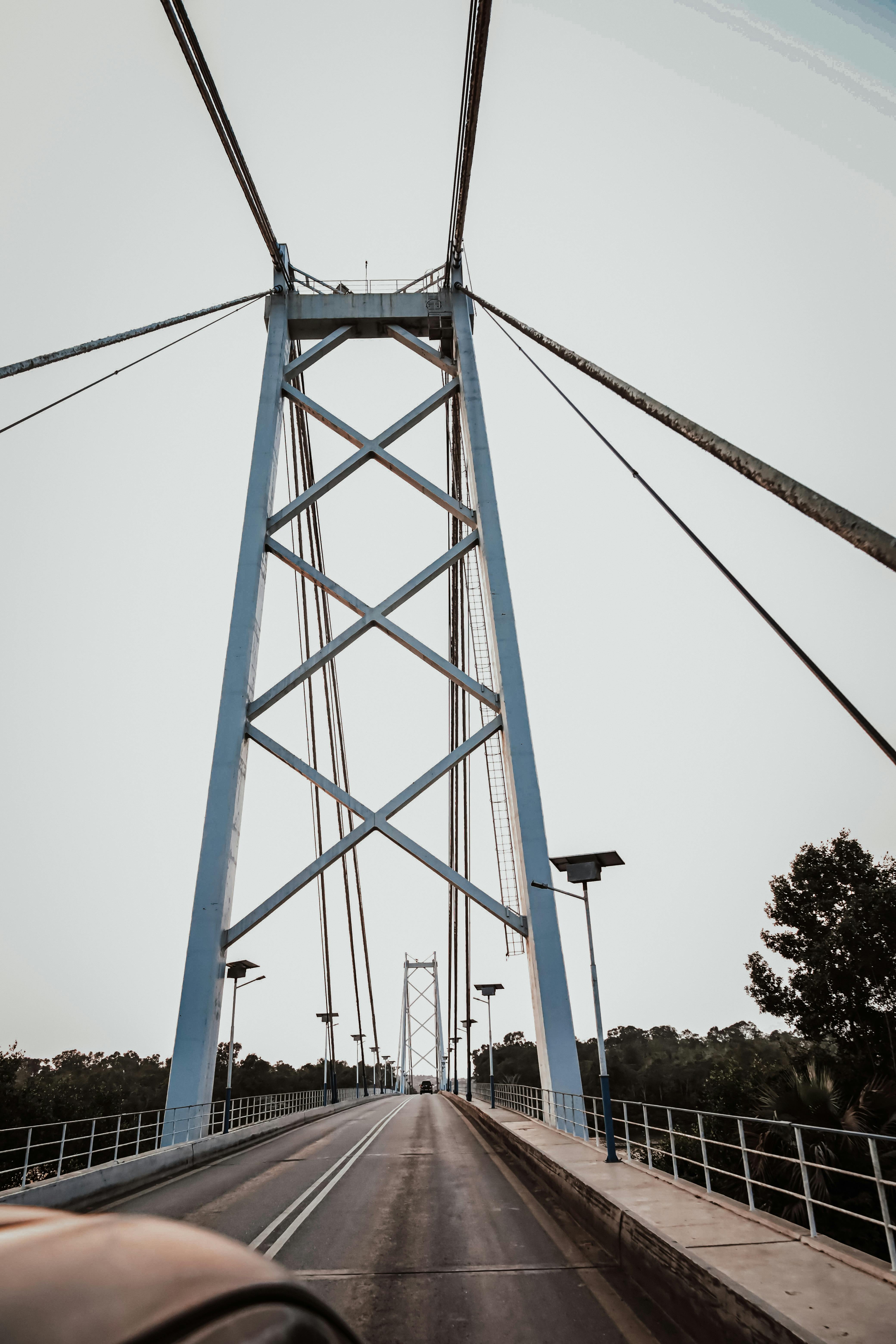 A car driving over a bridge with a view of the sky · Free Stock Photo