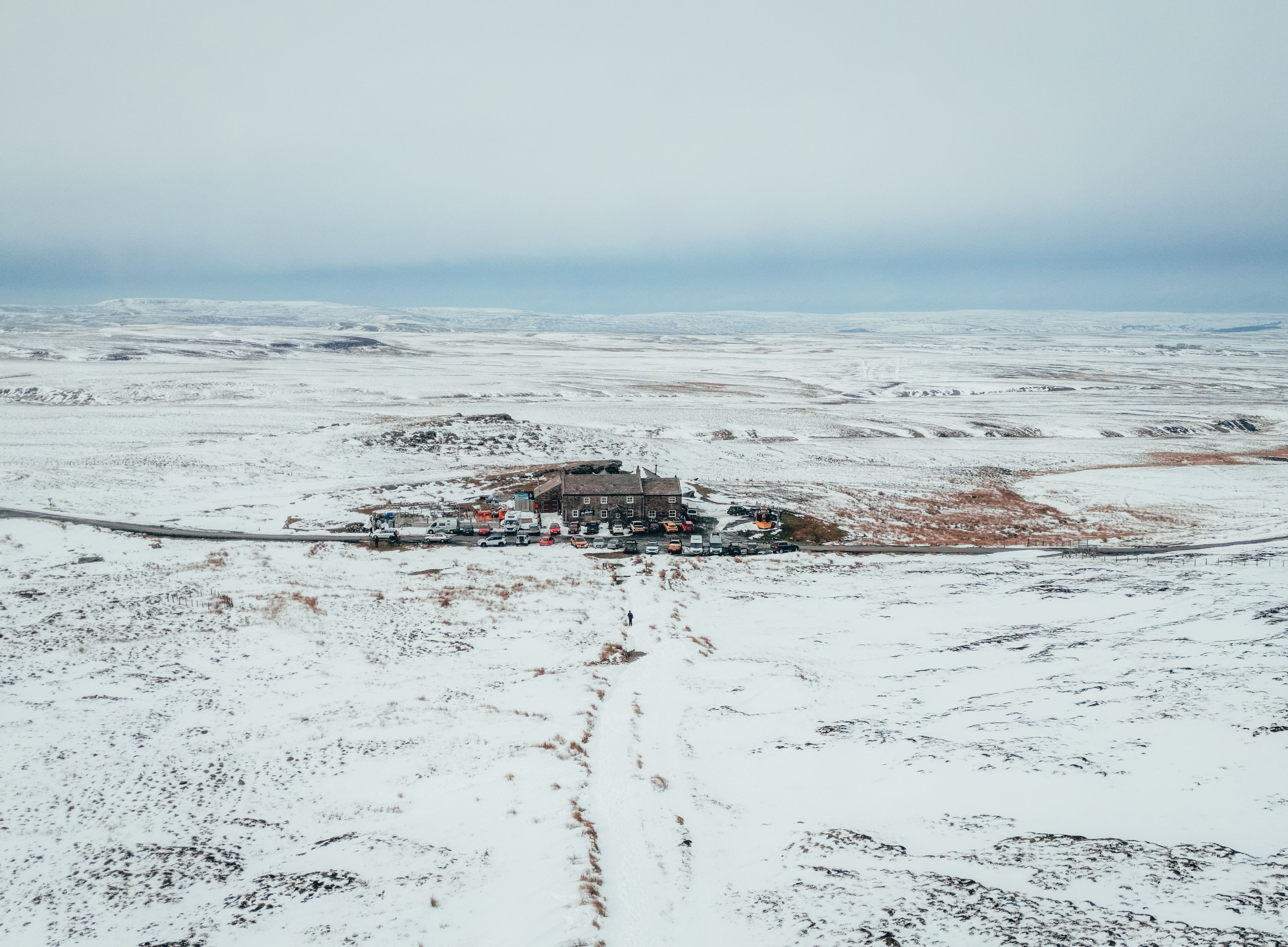 An aerial view of a snowy landscape with a building in the middle ...