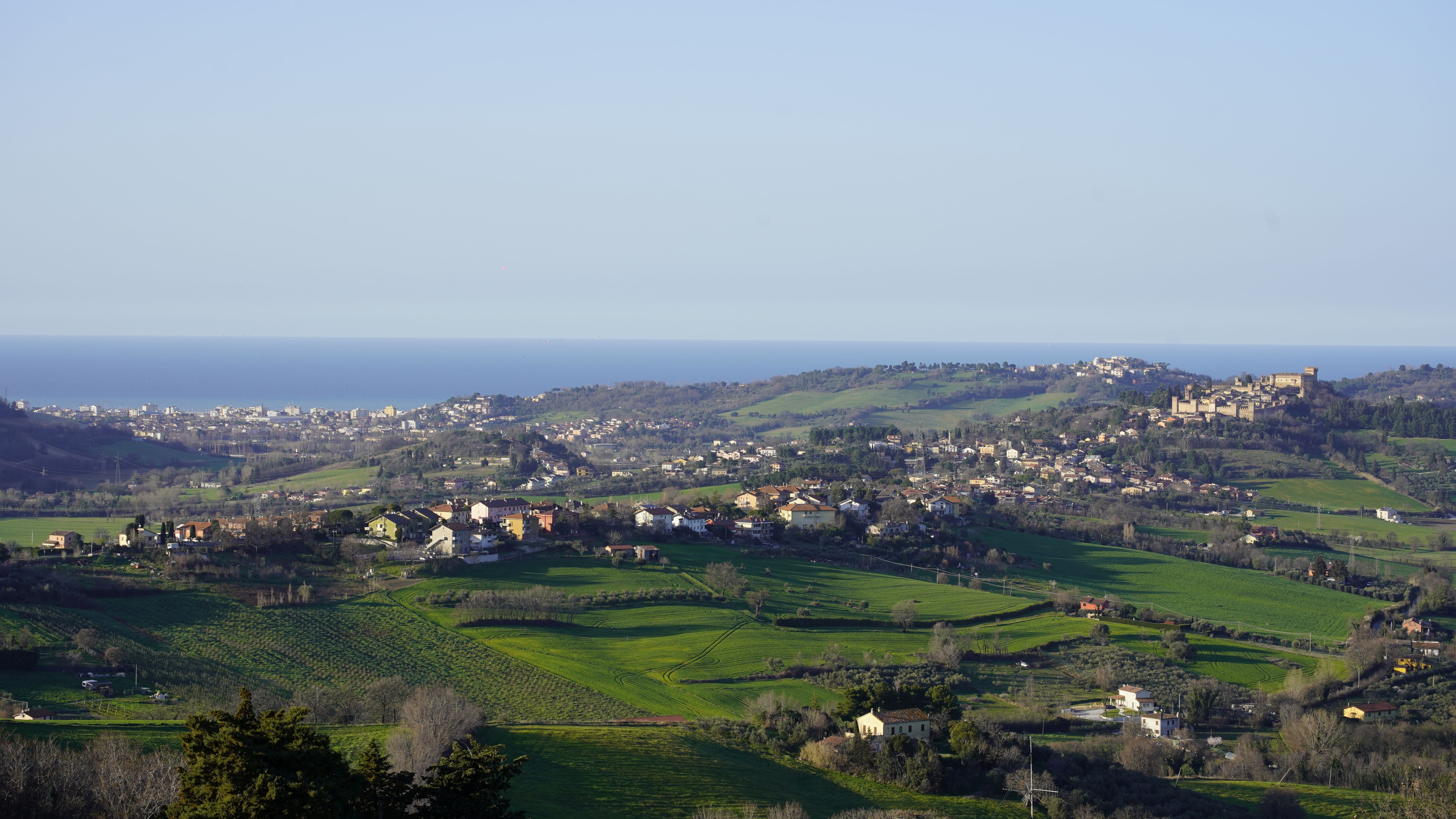 A view of the countryside with the ocean in the distance · Free Stock Photo