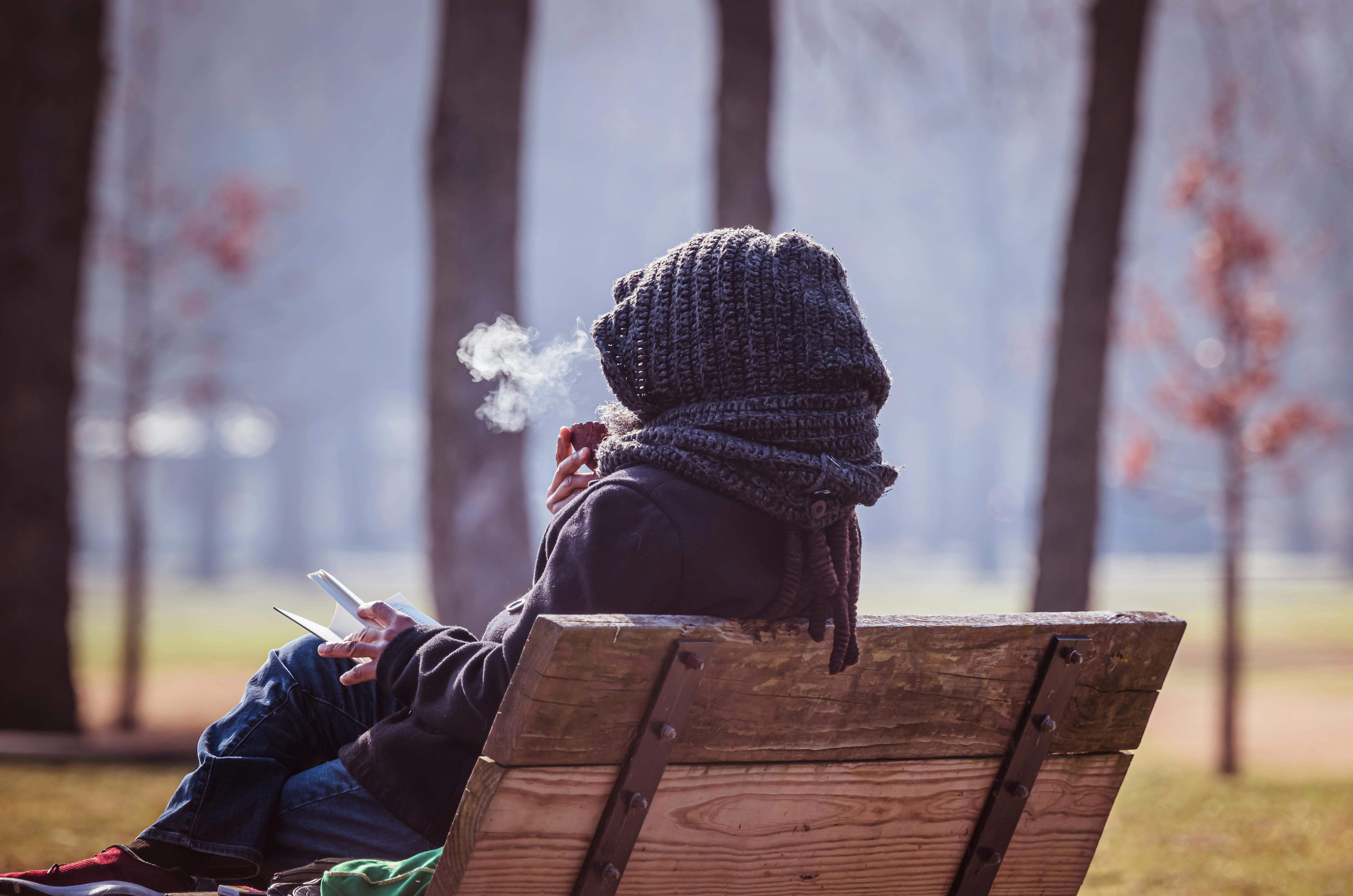 Person Sitting, Smoking and Reading Book · Free Stock Photo