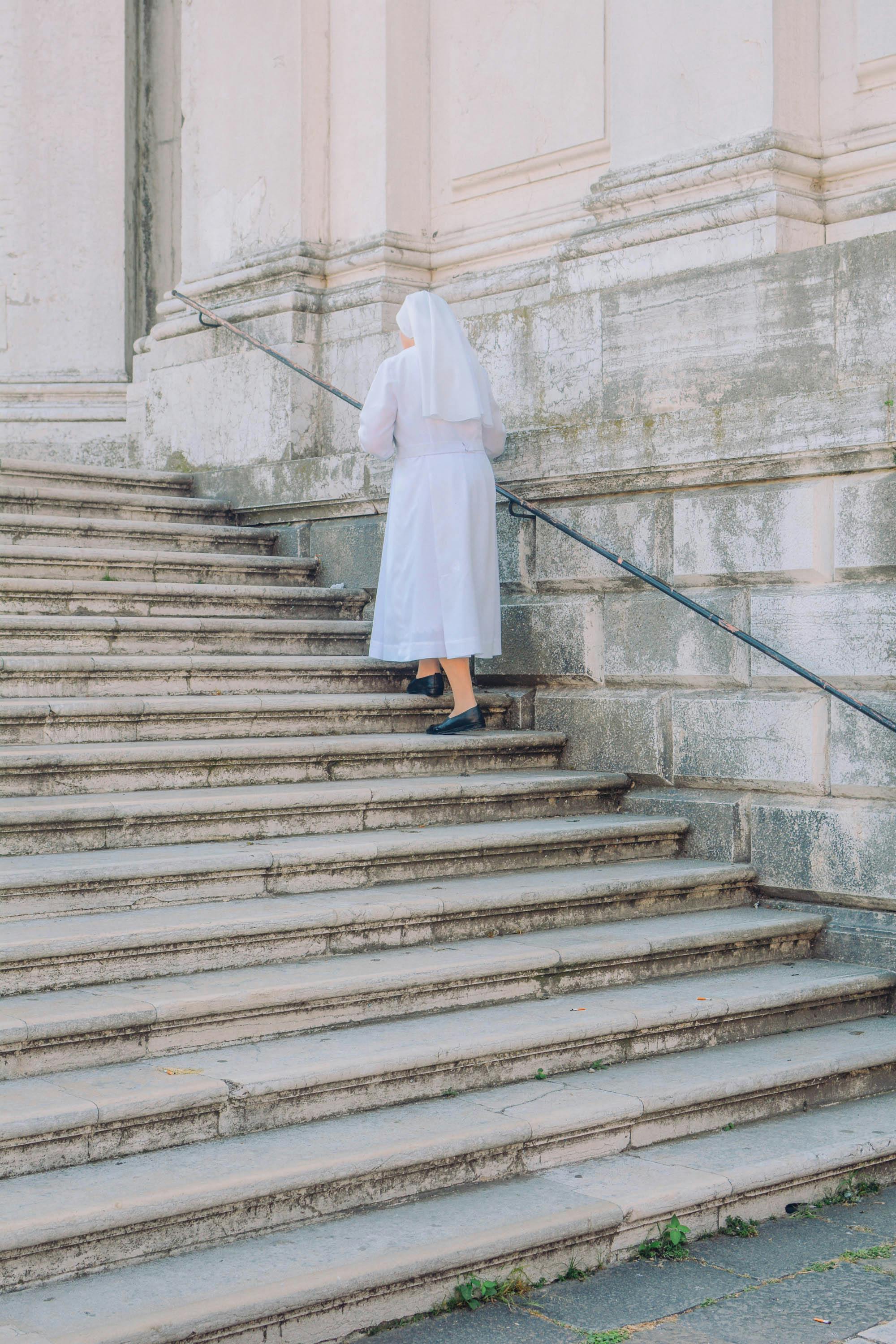Nun Walking Stairs to Old Cathedral · Free Stock Photo