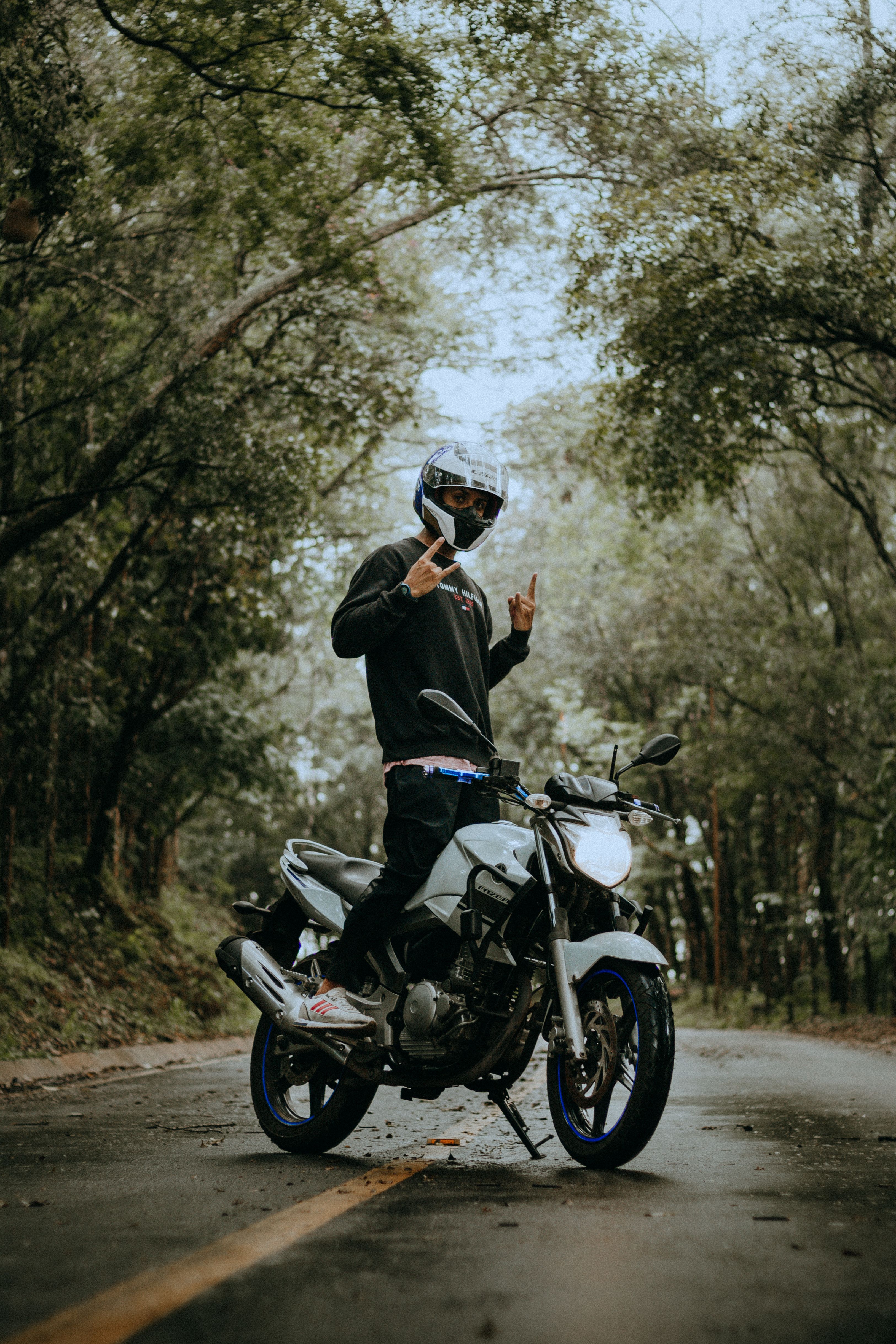 Amputee Standing between Friends Sitting on Motorcycles · Free Stock Photo