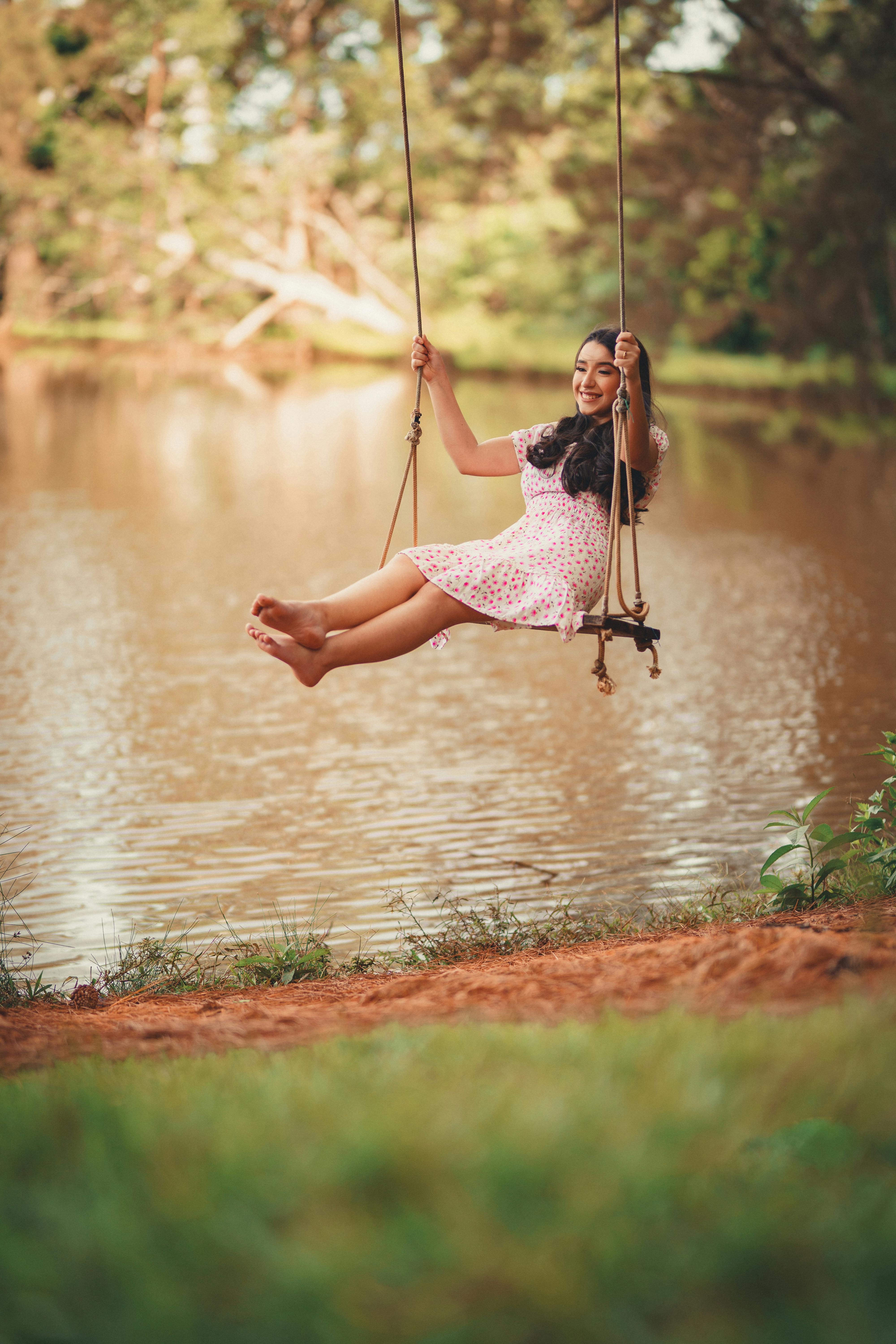 Woman Posing on Swing over Water · Free Stock Photo