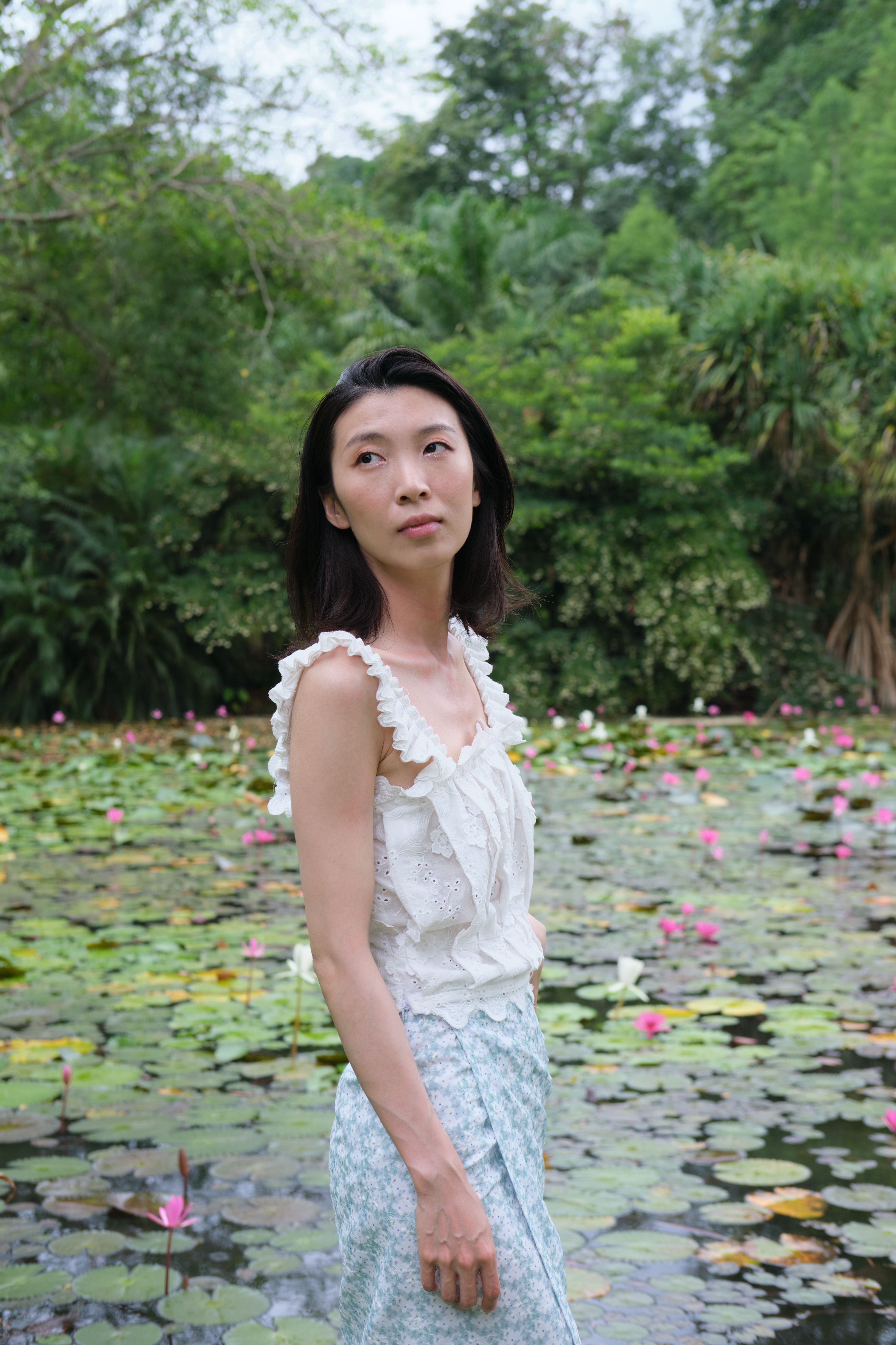 Female Model Posing in Front of a Pond Filled with Water Lilies · Free ...