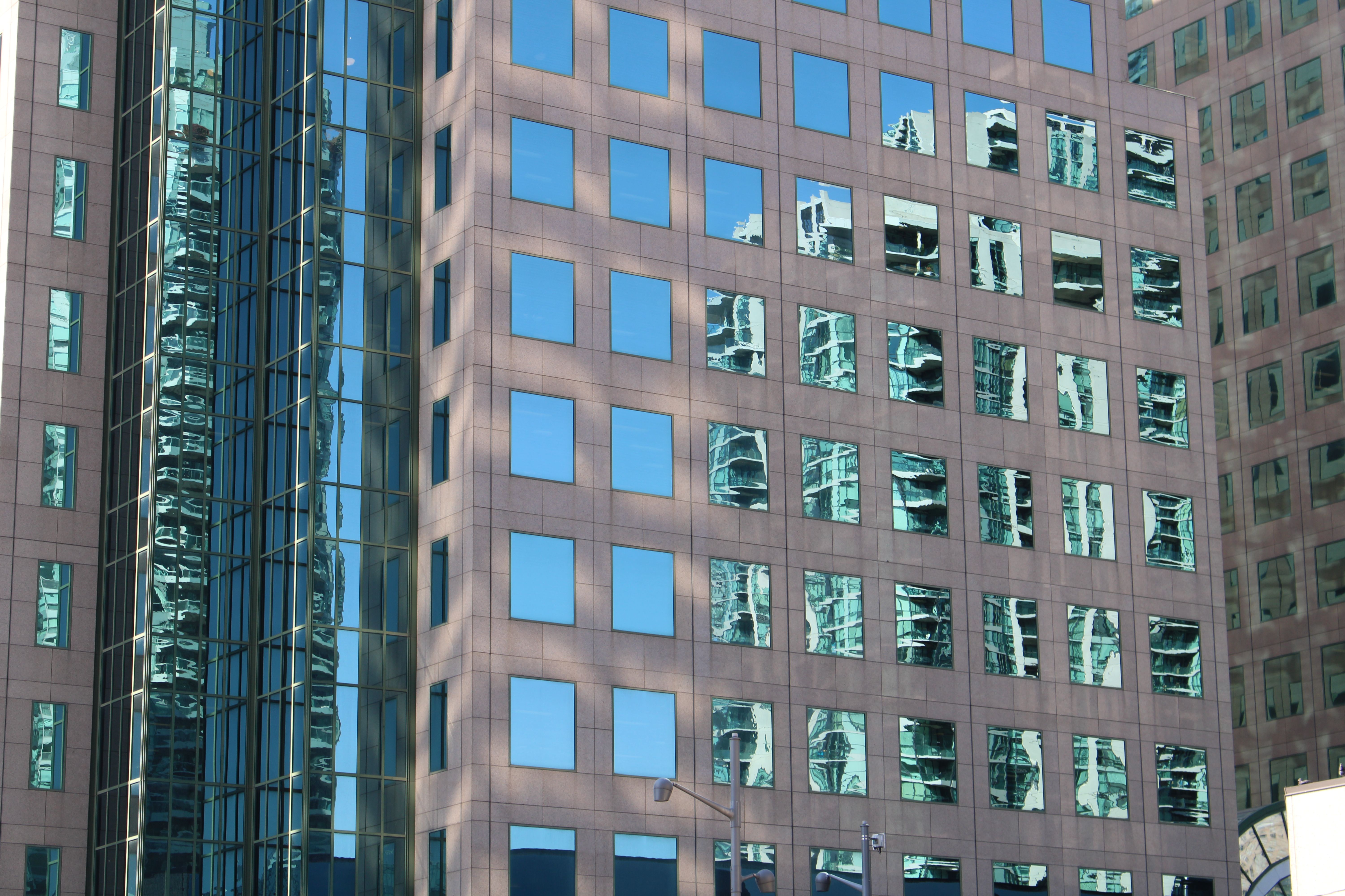 Low Angle View of Glass High Rise Building during Cloudy Daytime Photo ...